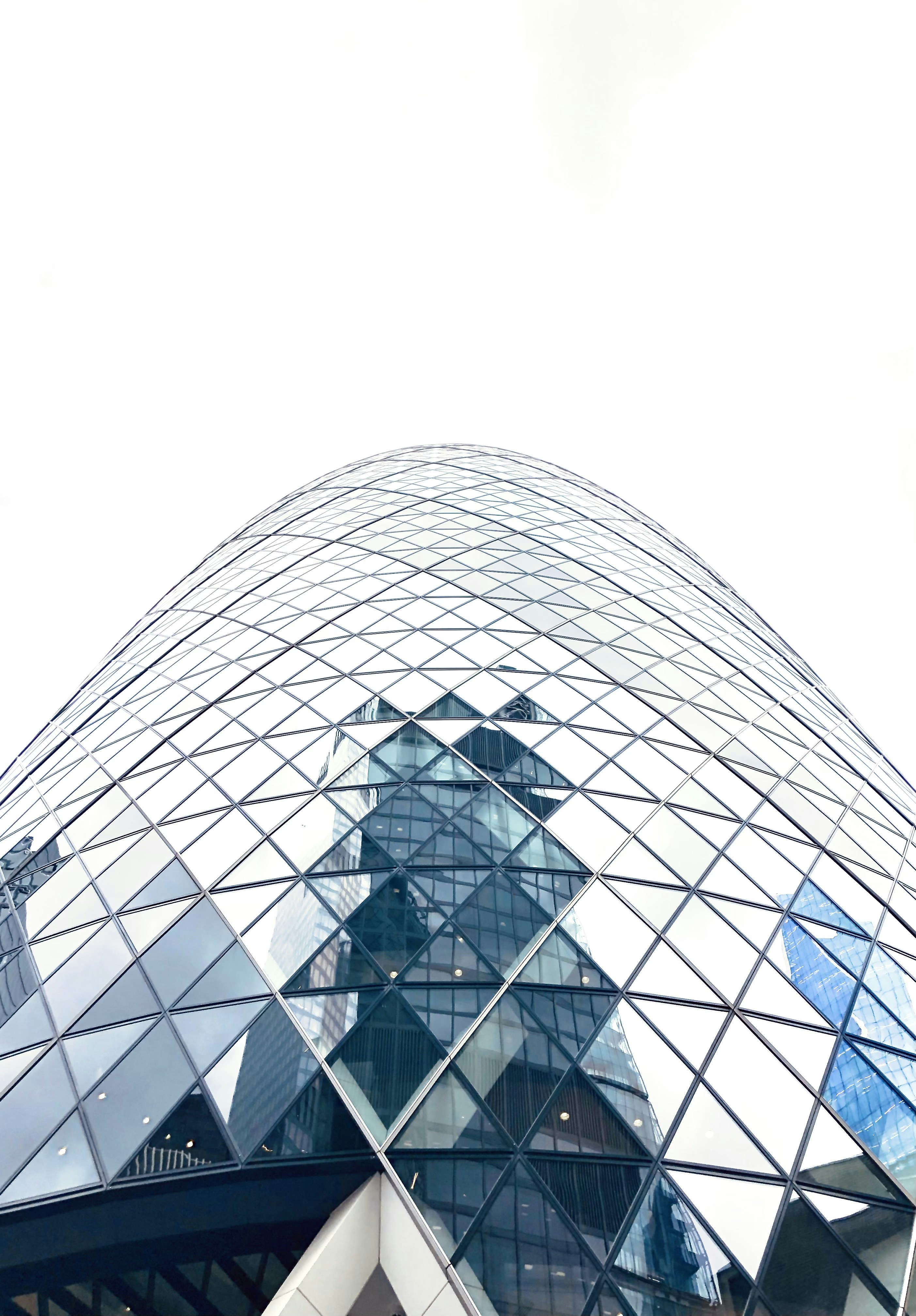 Architectural marvel showcasing a glass facade with intricate diamond patterns, reflecting surrounding skyscrapers. The upward angle emphasizes the structure's height and design.
