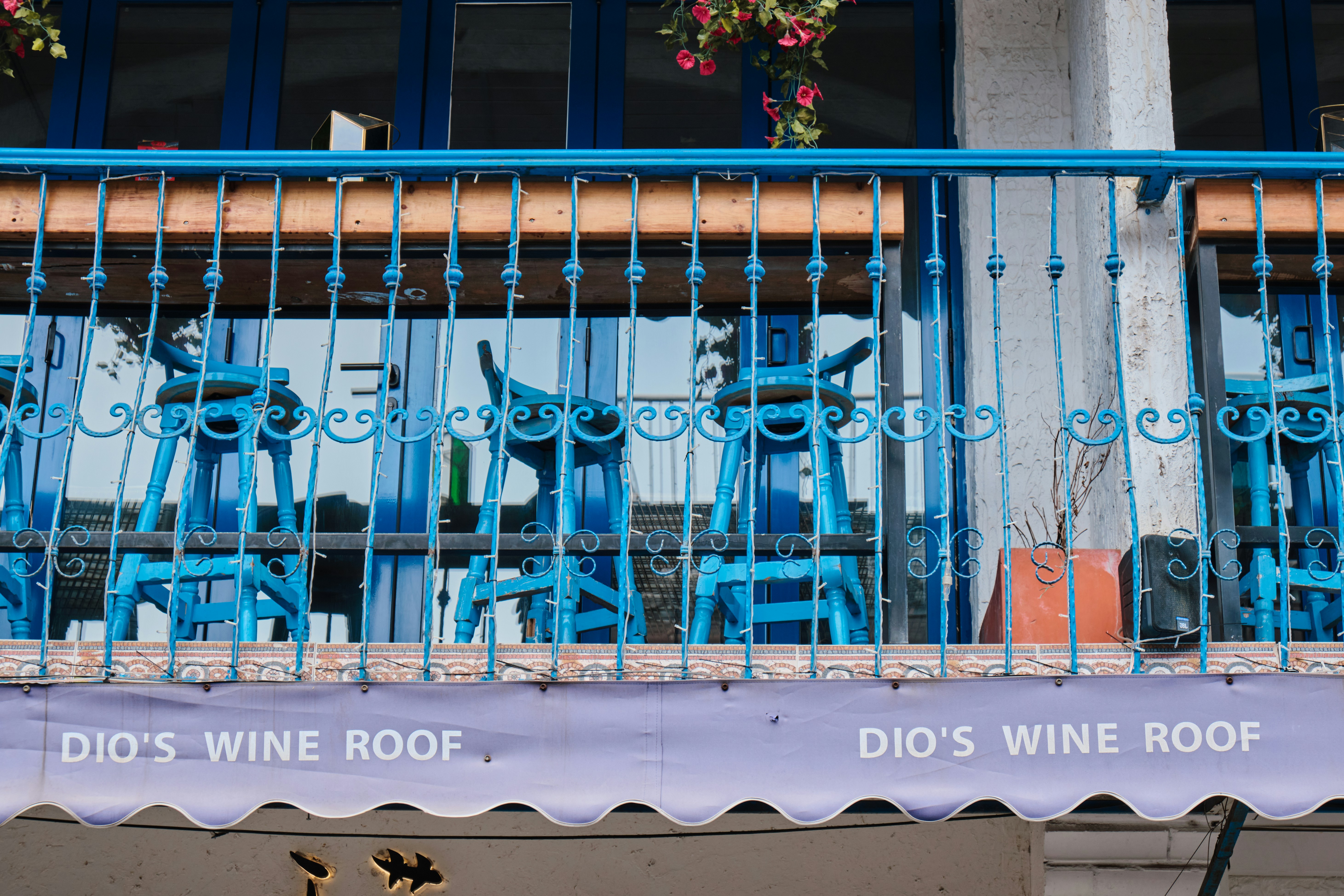 Azure Balcony Choir: Blue Chairs Under a Purple Awning