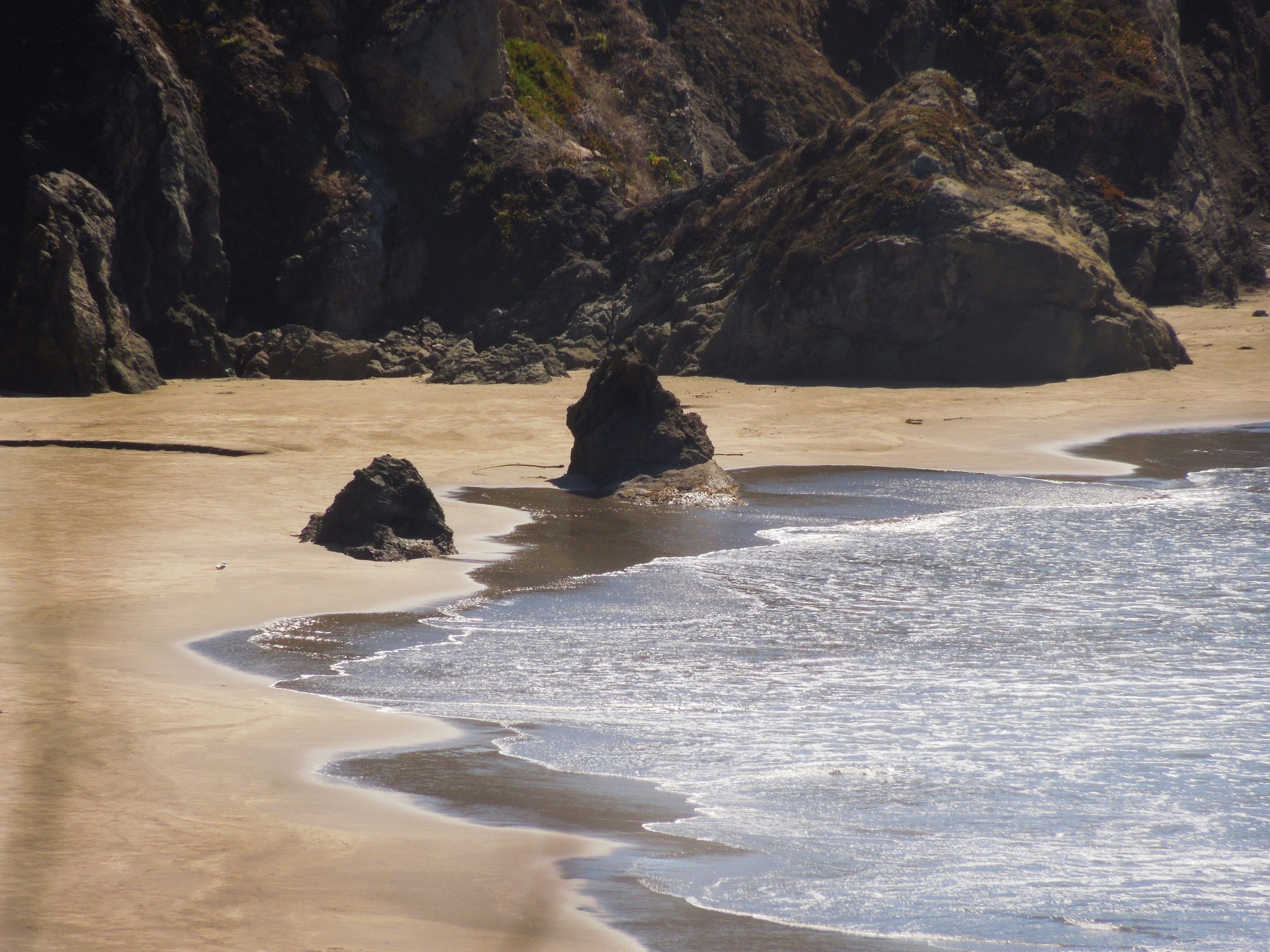 Brown sand beach with brown rock formation photo – Free Beach Image on ...