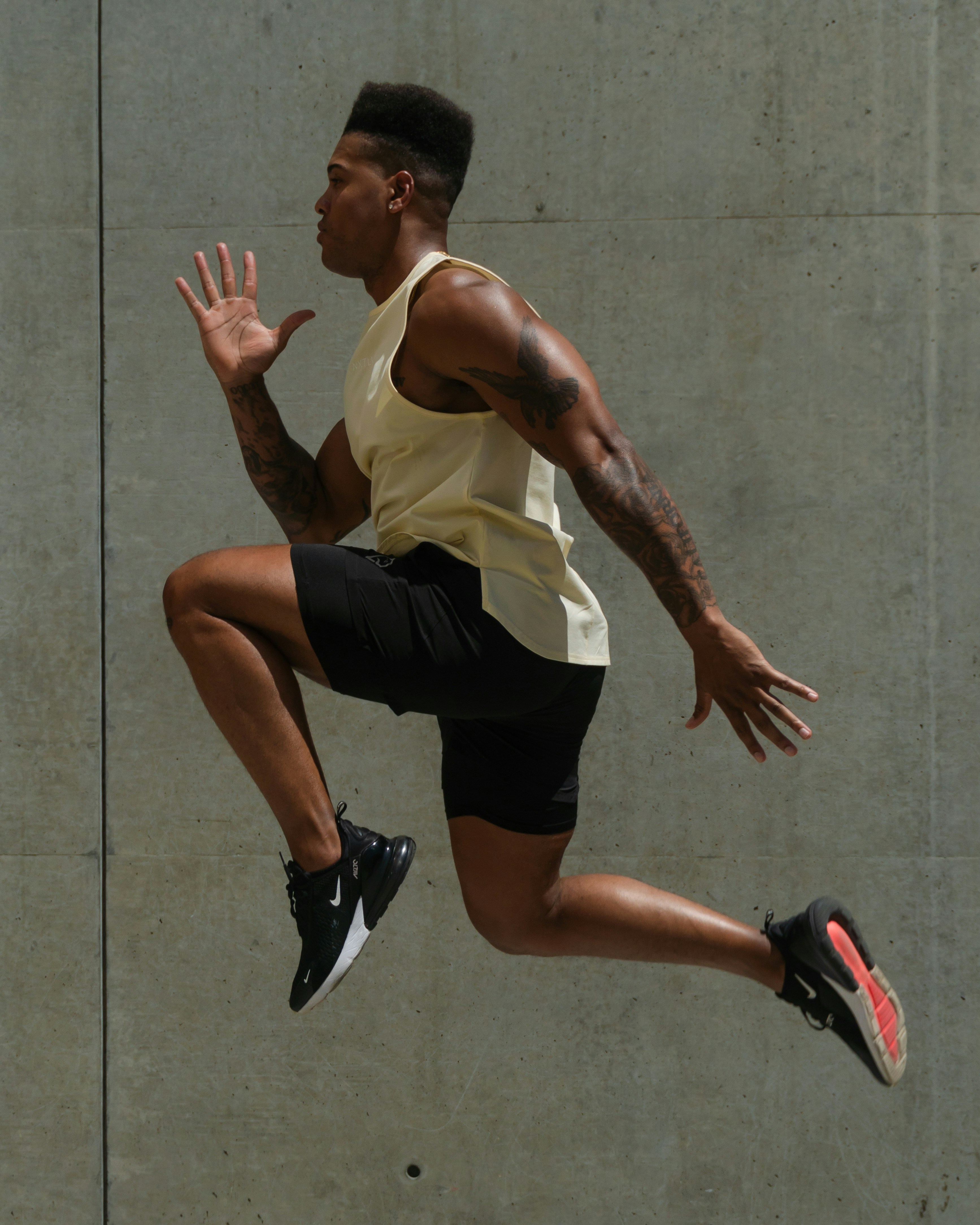 Urban Leap: A Sprinter Frozen in Midair Against Raw Concrete