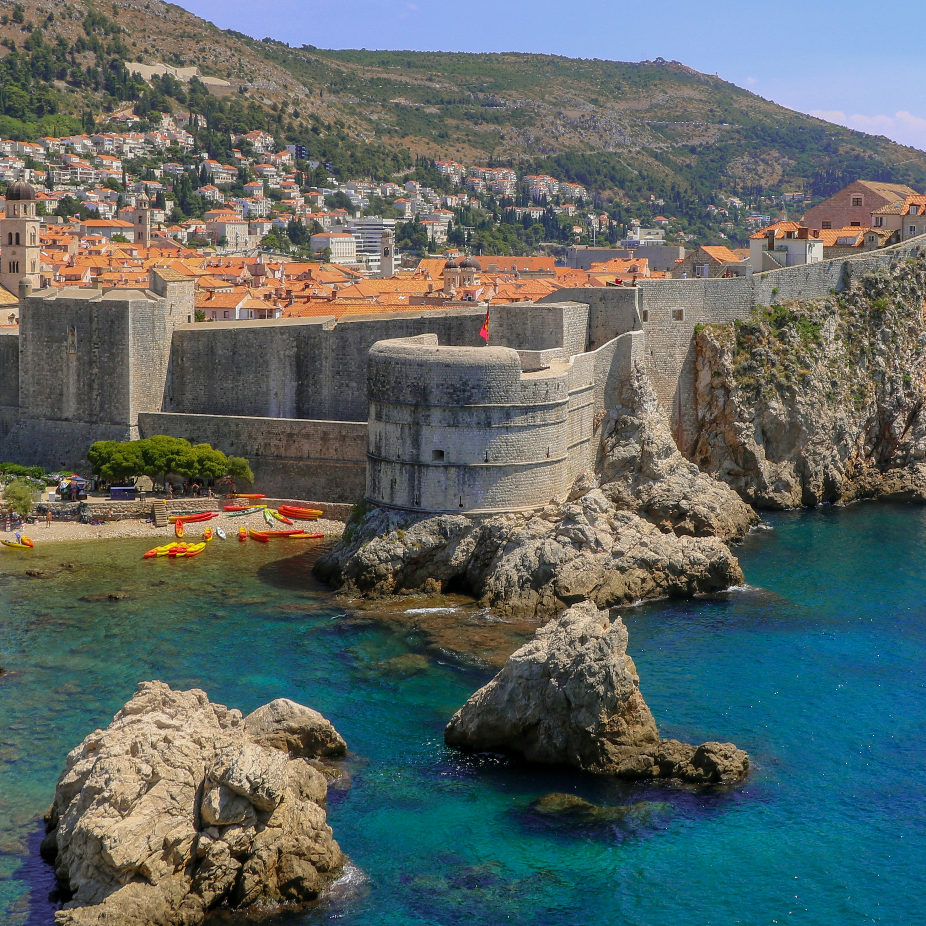 Coastal Fortress Overlook: Turquoise Waters and Terracotta Roofs