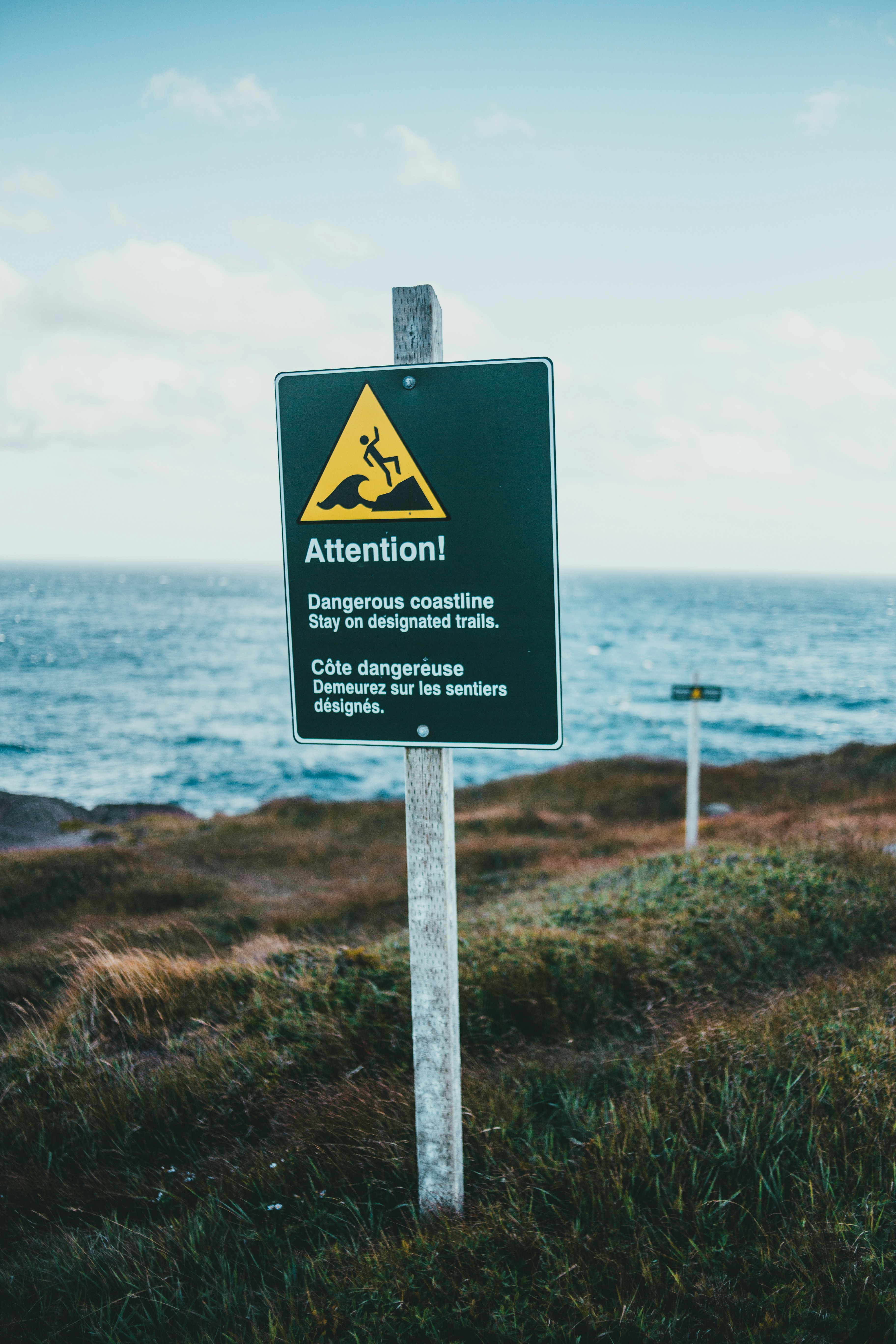 Warning Sign by the Sea: A Quiet Path Along a Rocky Coastline