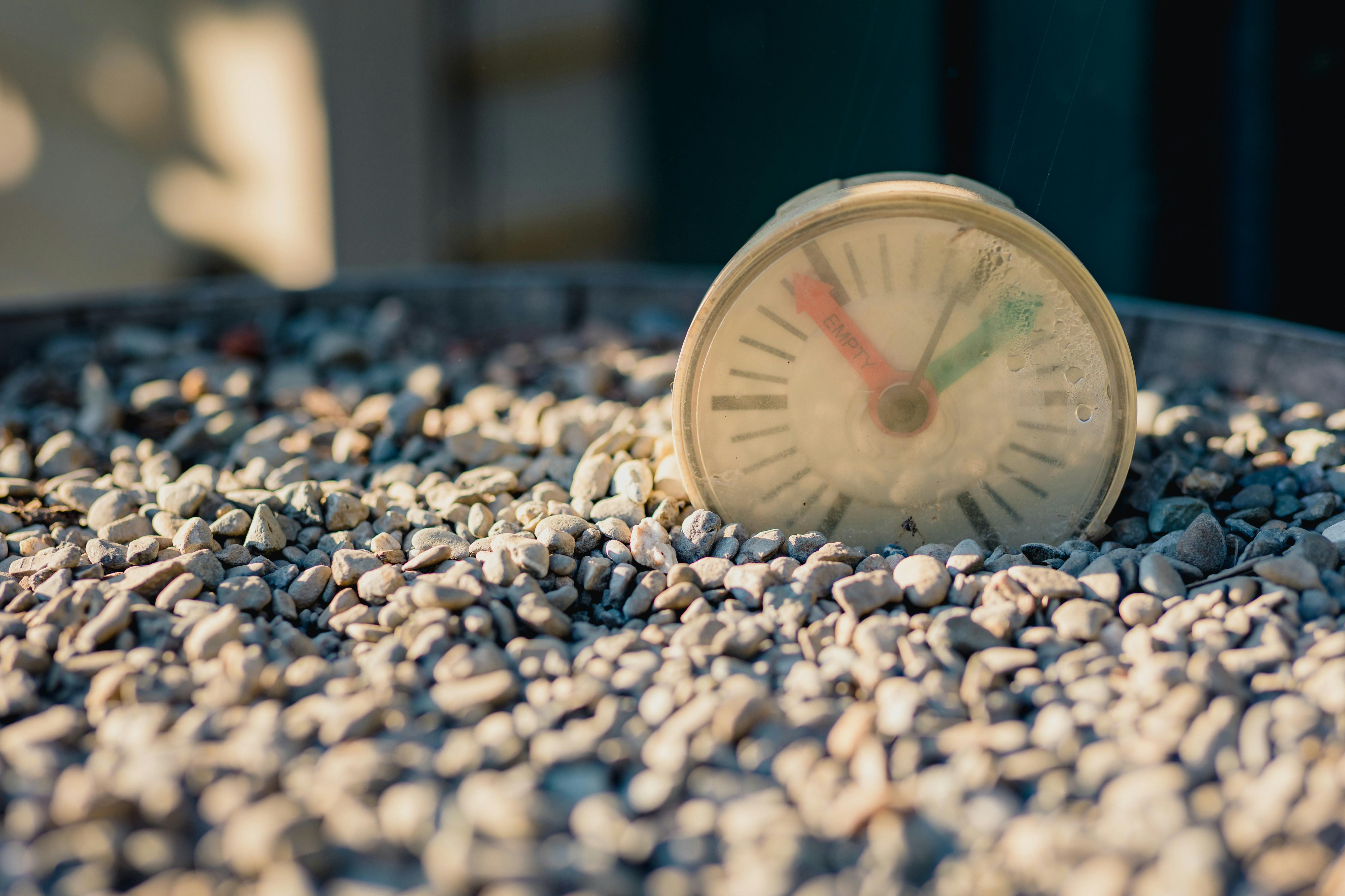 Weathered Compass Resting on Gravel with Soft Backdrop