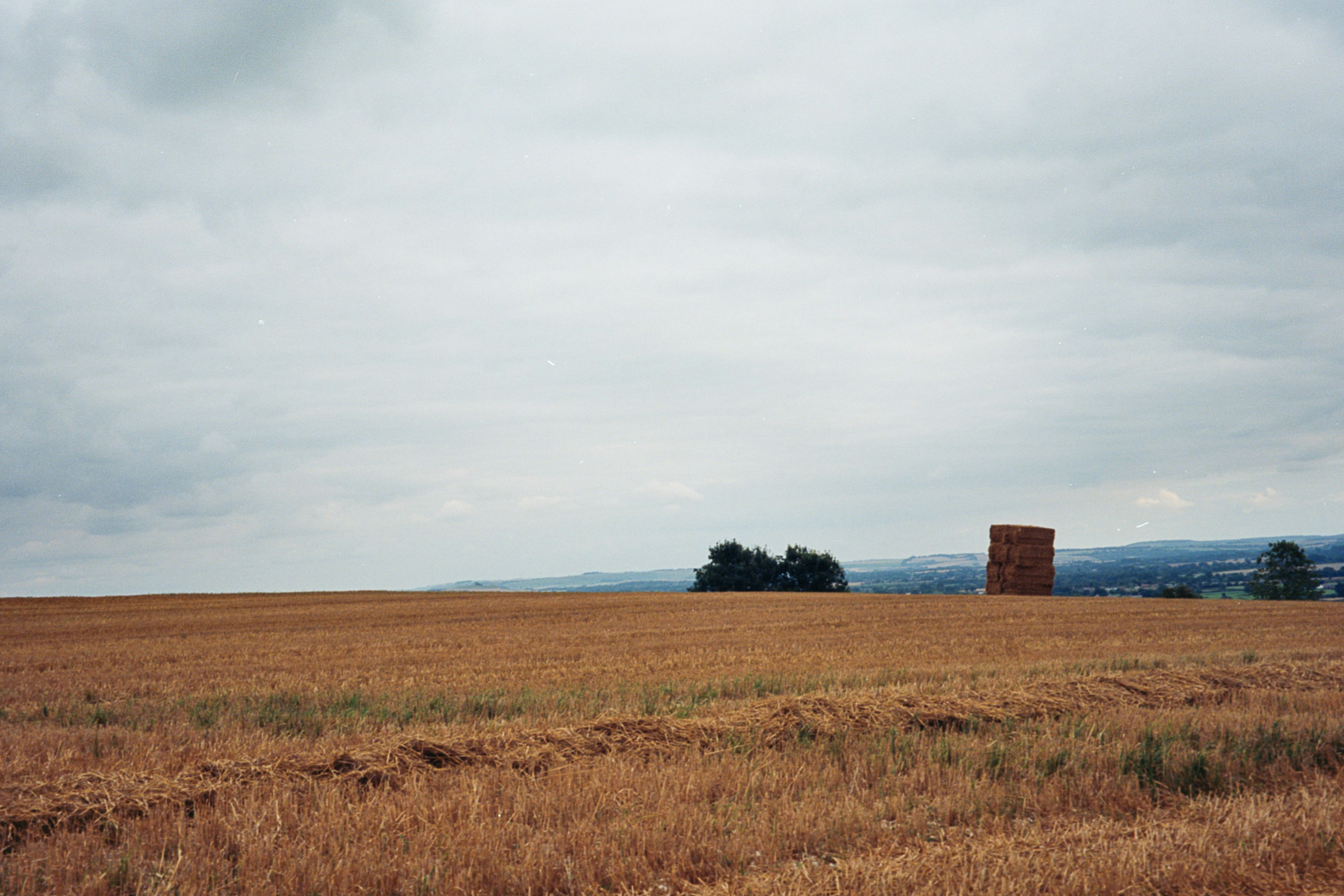 A field with a hay bail in the middle of it photo – Free Devizes Image ...