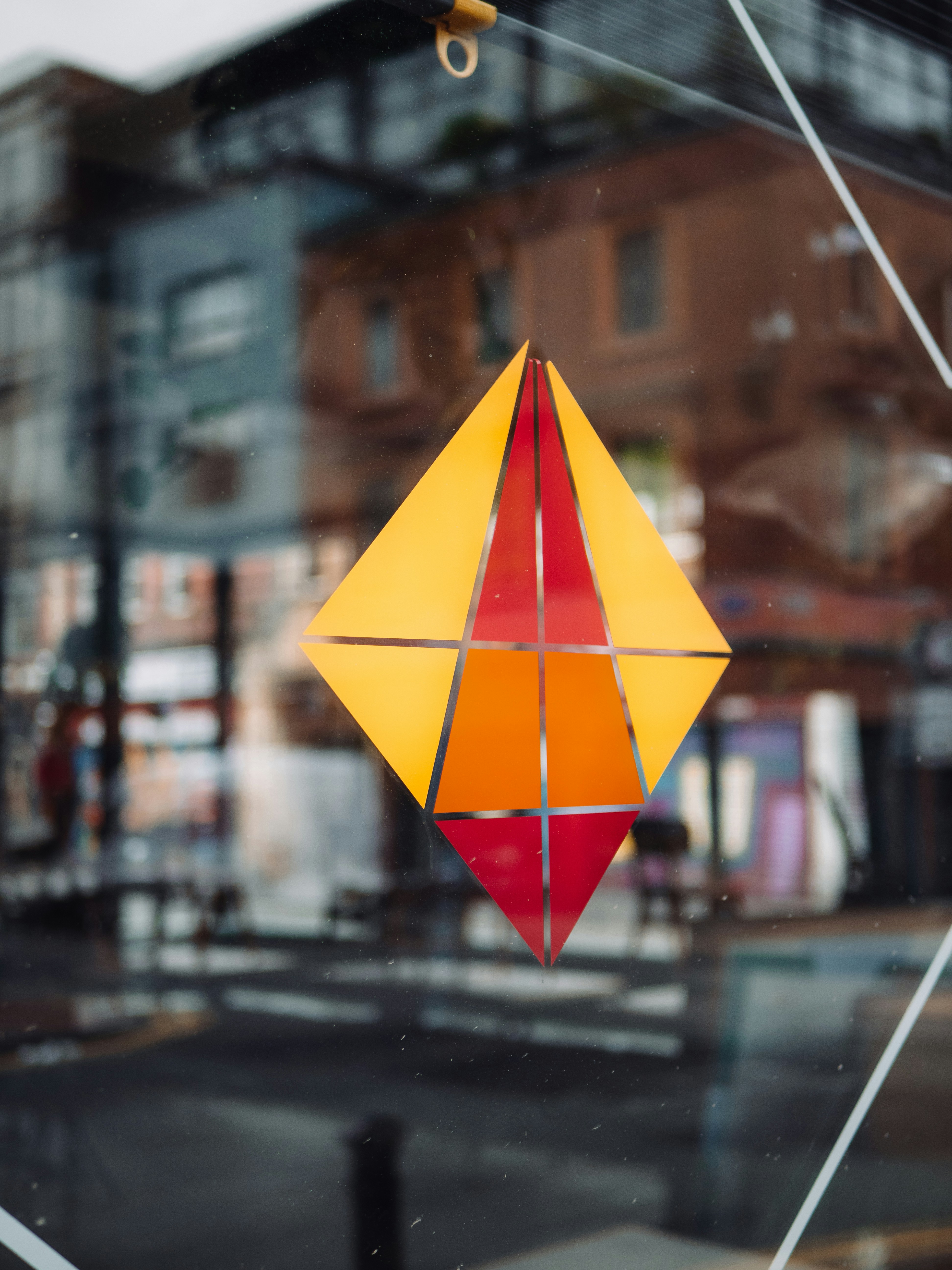 Prismatic Diamond in a Glass Window: An Urban Emblem Framed by Reflection
