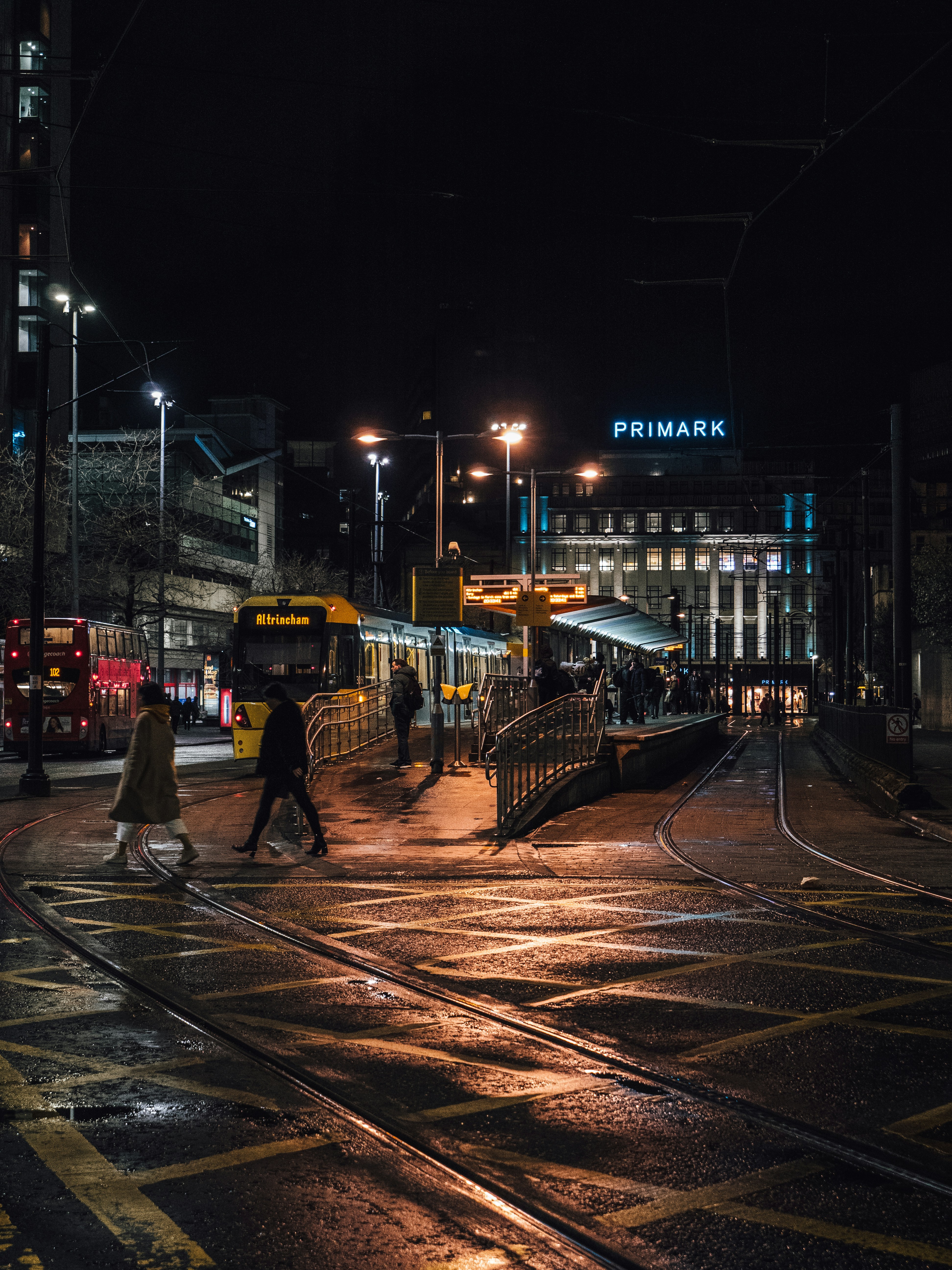 Neon Rain at the Tram Stop: Wet Tracks, Warm Light, and City Pulse