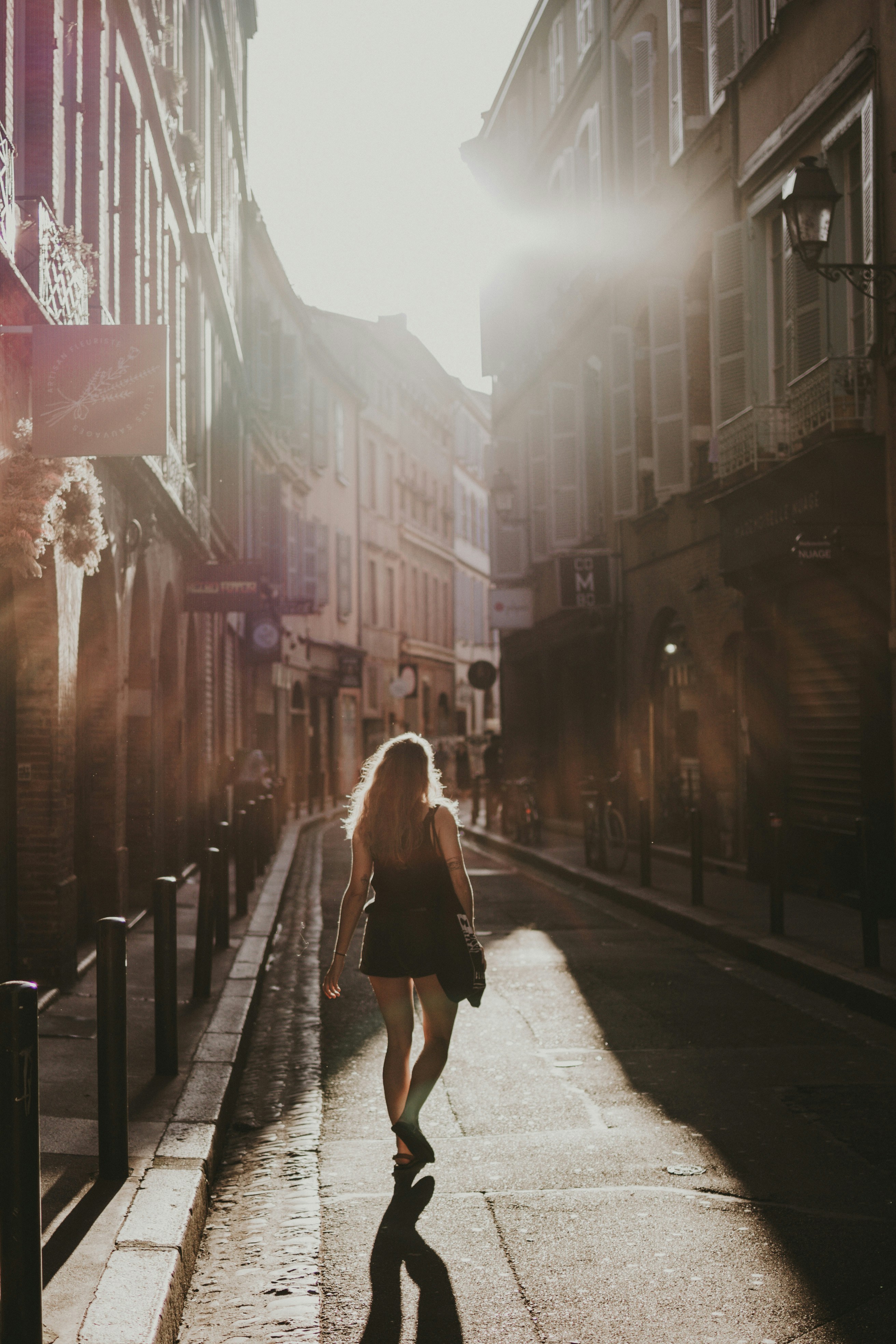 Golden Hour Solace: A lone figure strides down a sunlit city lane