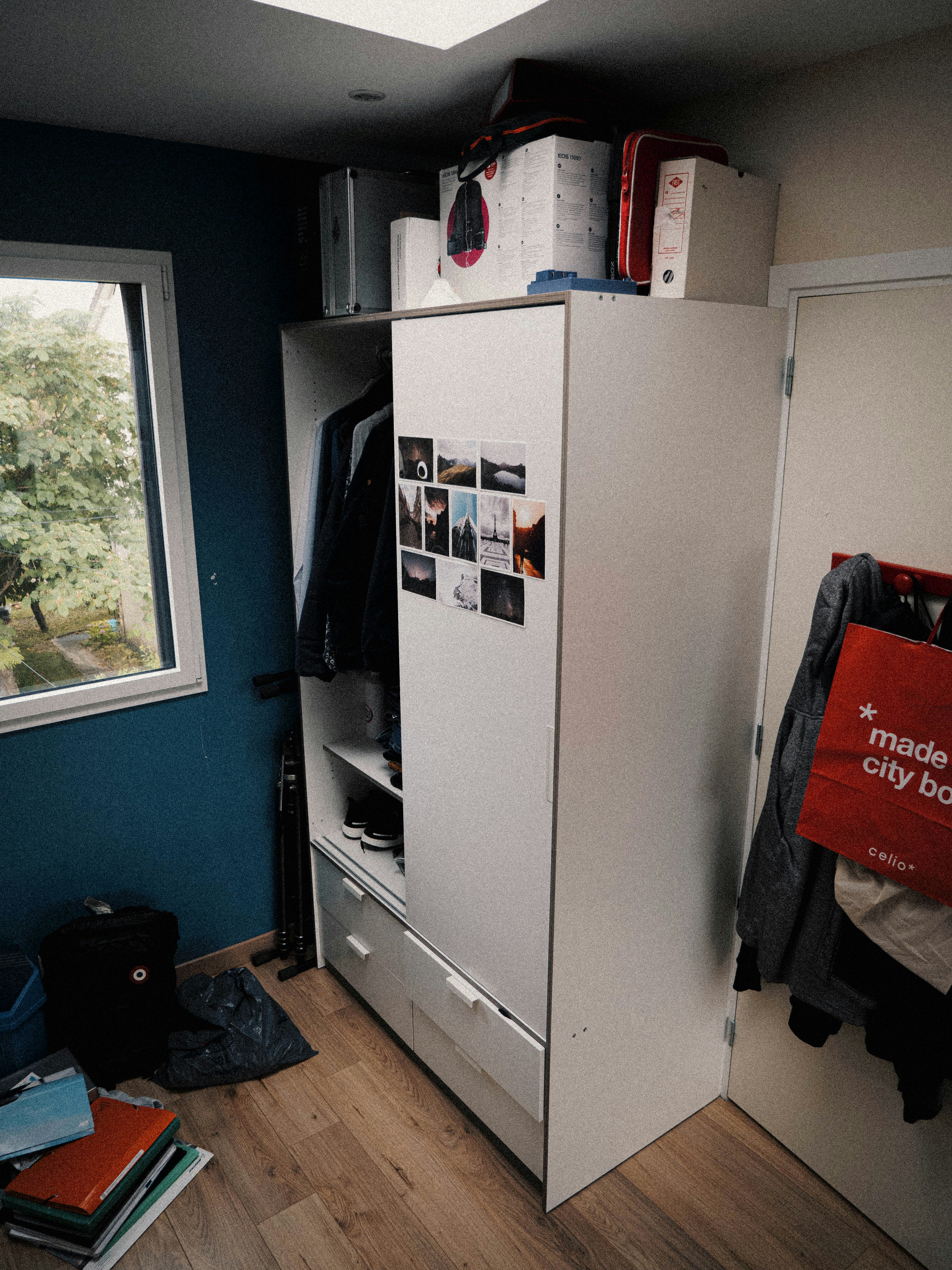 White top mount refrigerator beside white wooden framed glass window ...