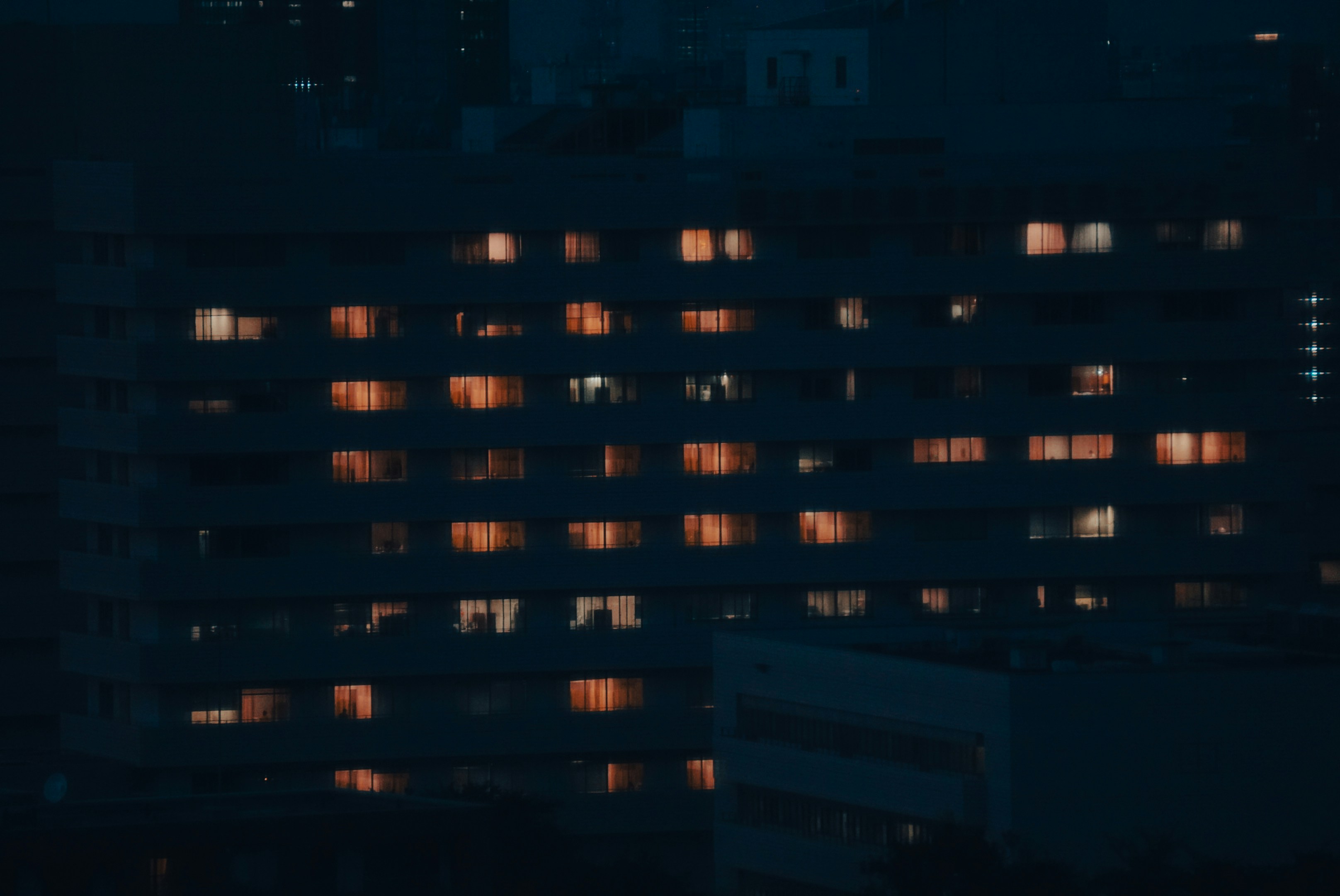 A very tall building with lots of windows at night photo – Free ...