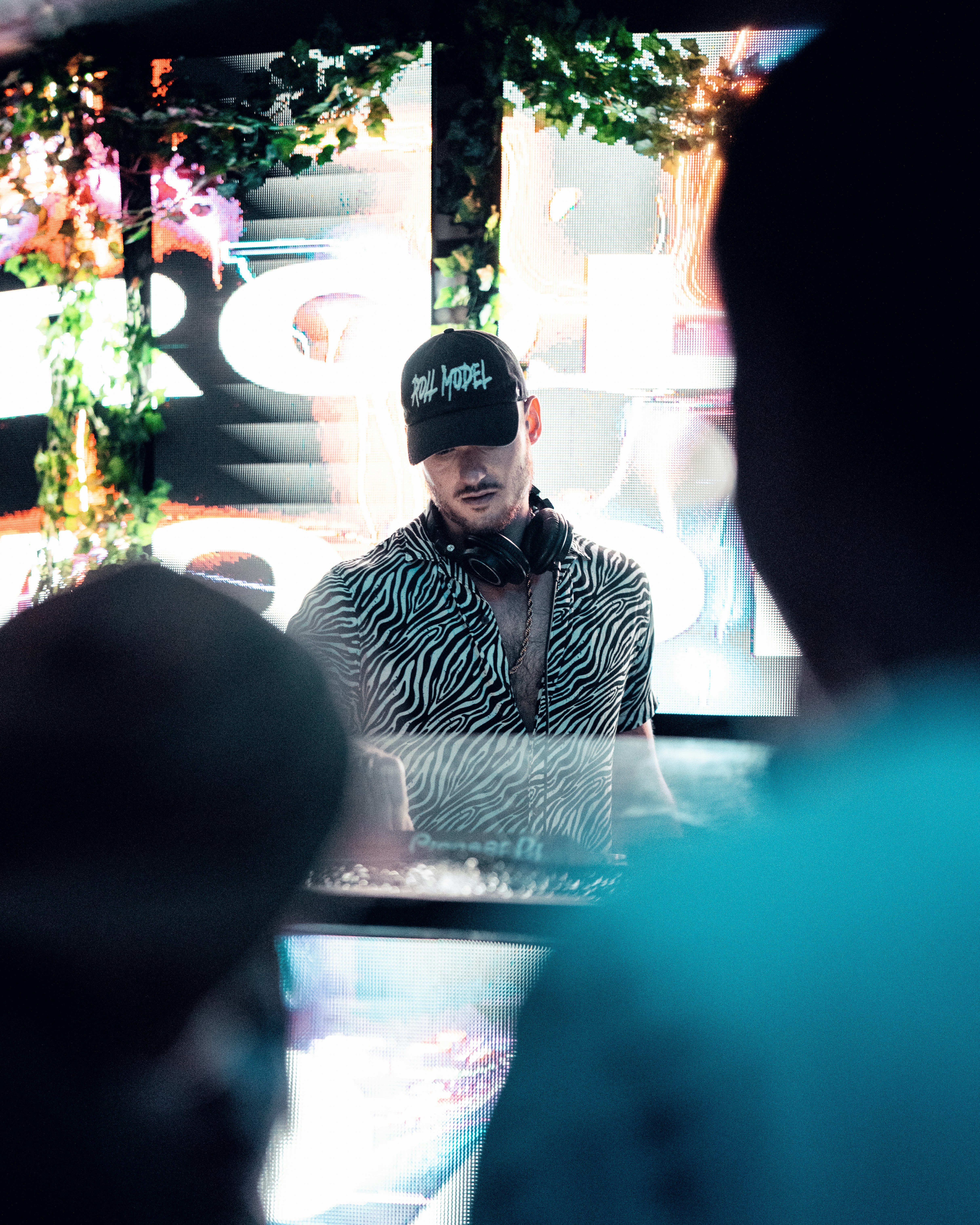 Midnight Pulse: A DJ in Zebra Stripes Behind Neon Art