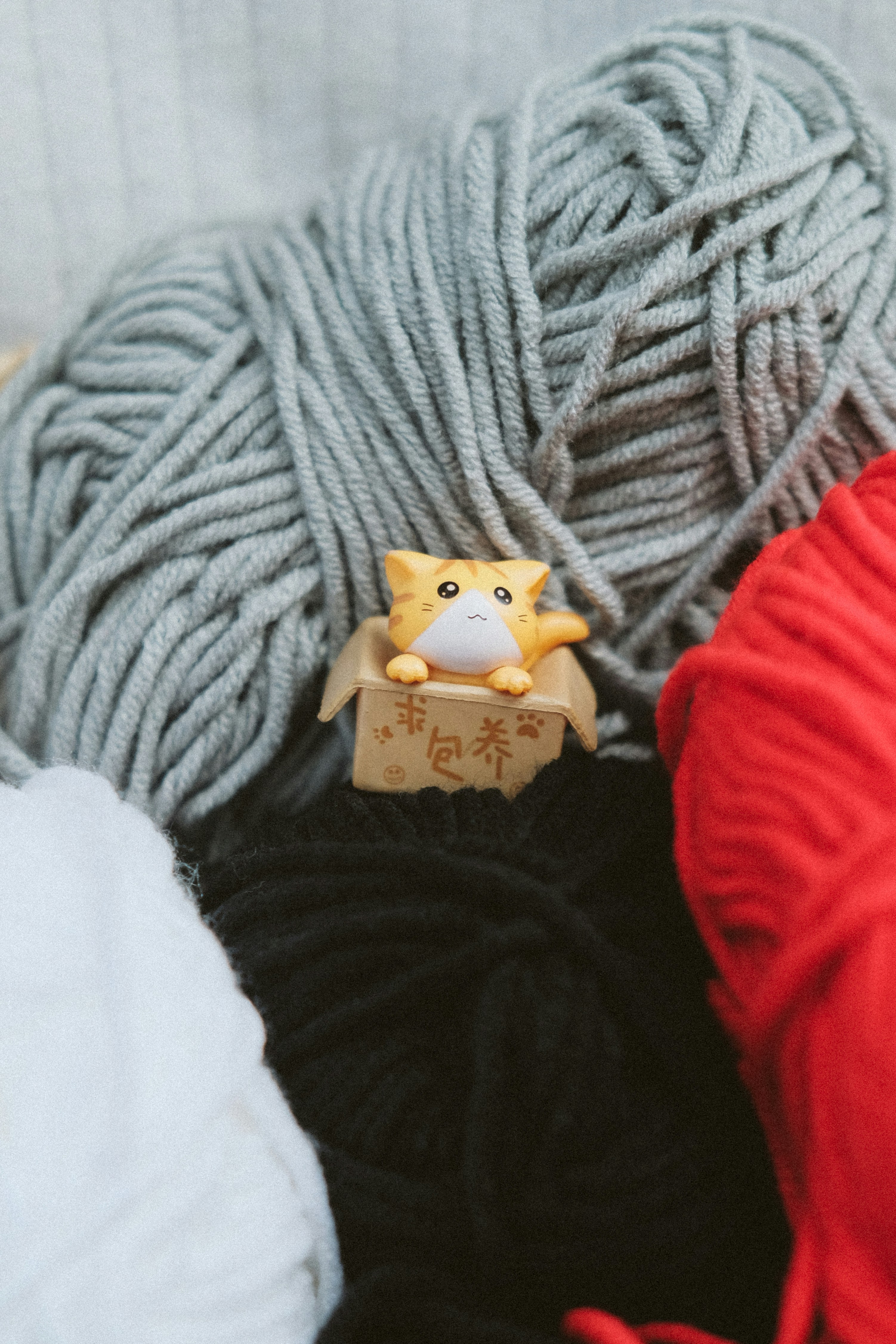 Whiskered Messenger: A Toy Cat Emerges from a Nest of Yarn