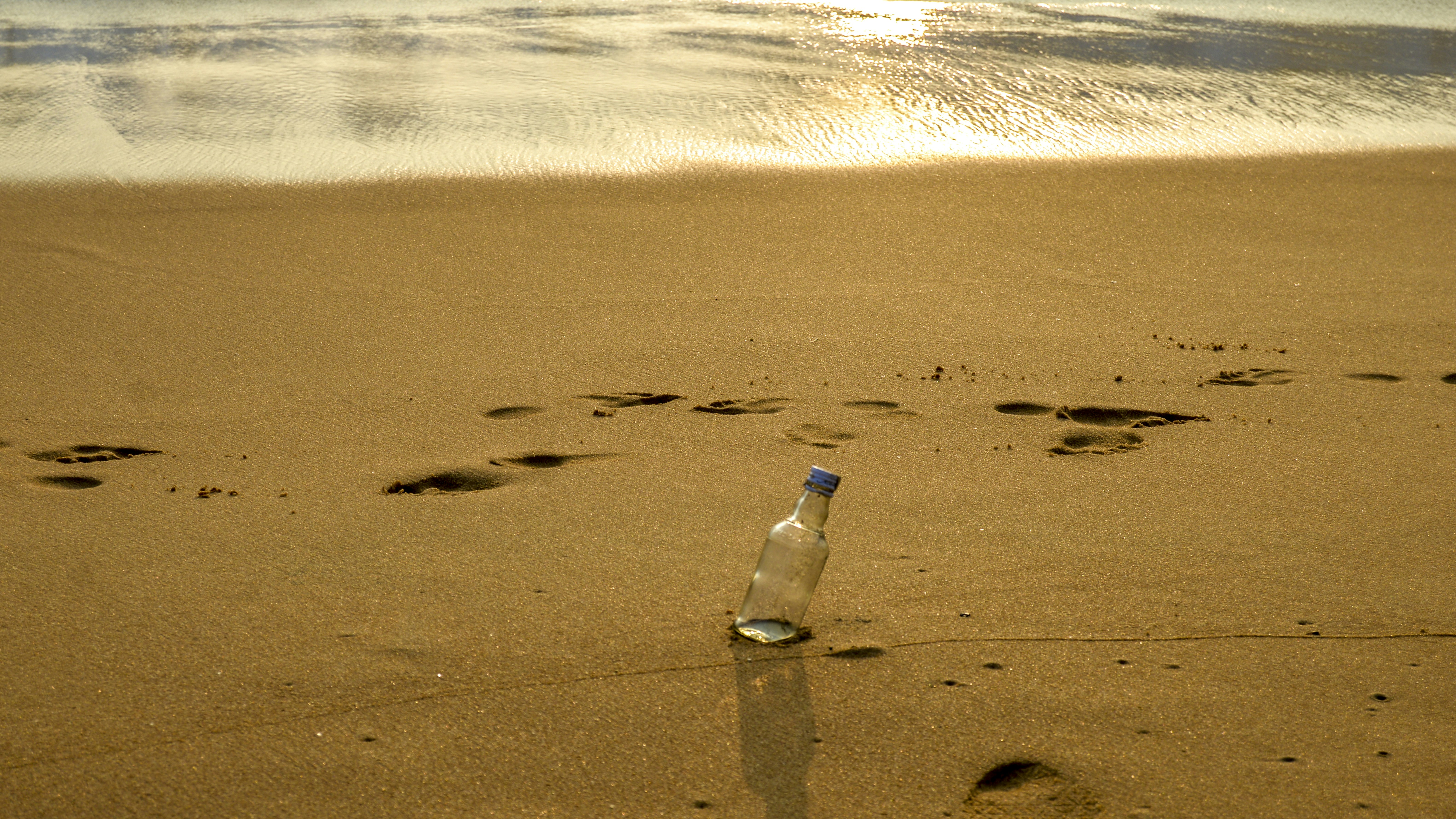 Solitary Bottle at Golden Hour on a Quiet Beach