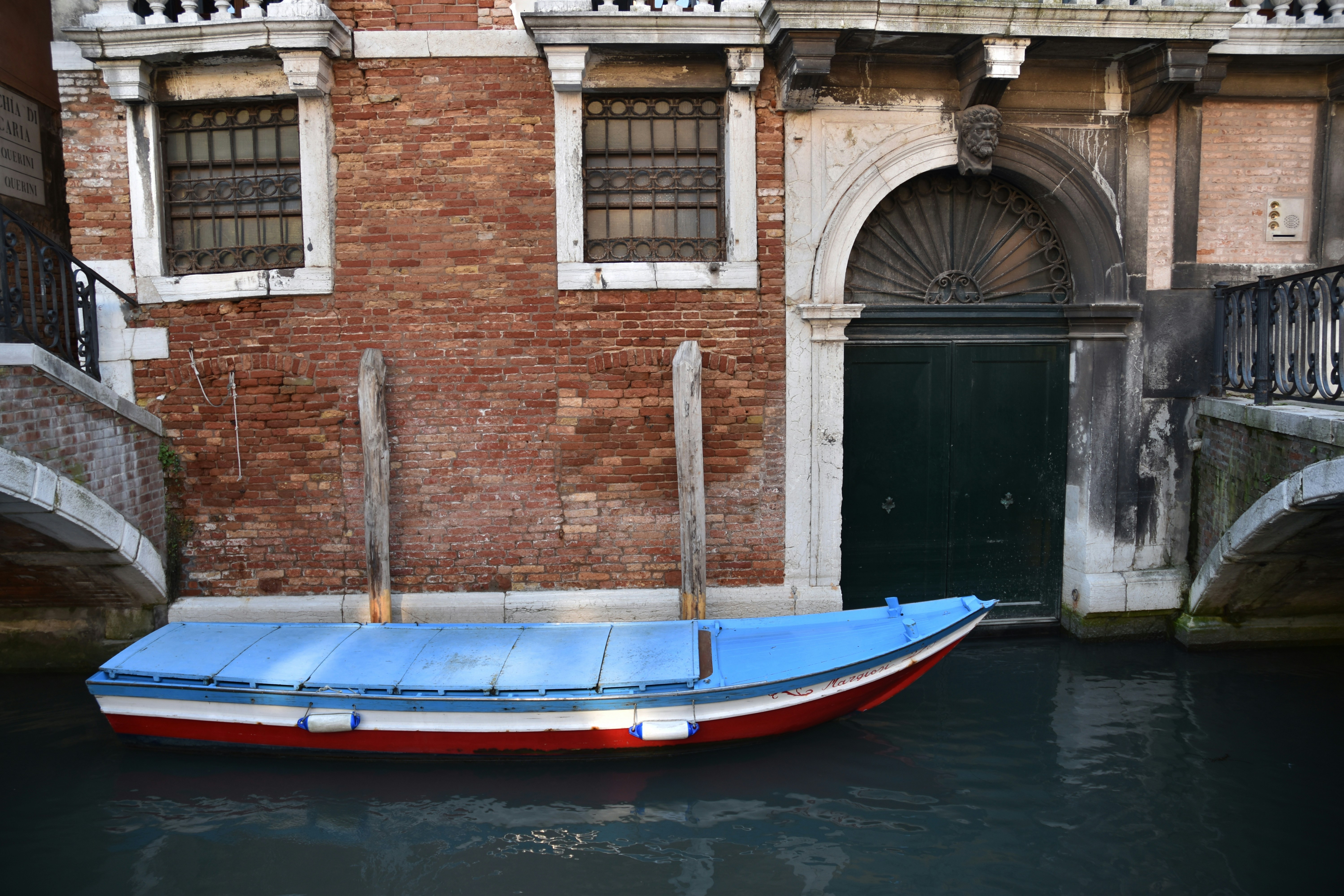 a boat is docked in a canal next to a building