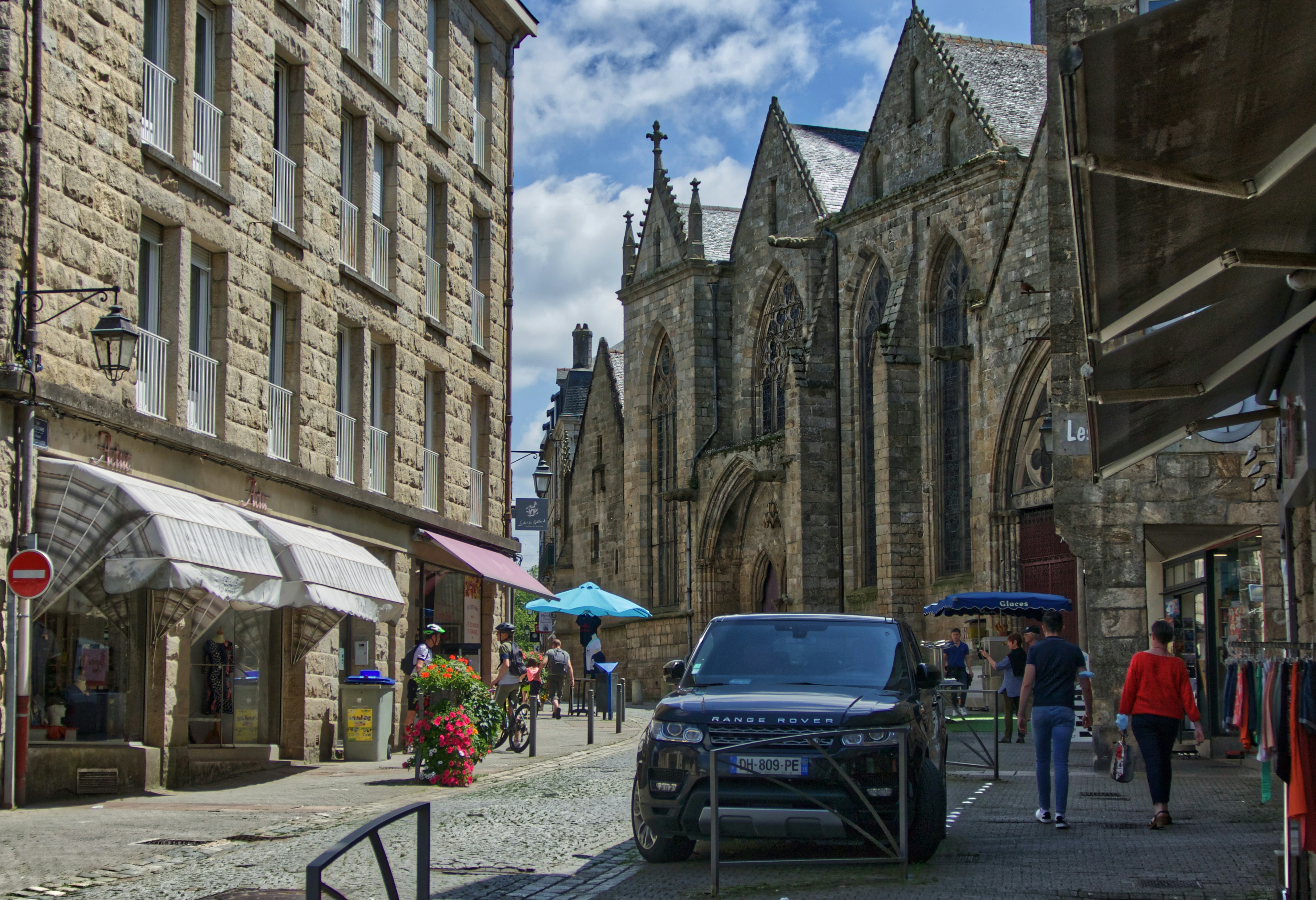 Streetside Cathedral Vista: Market, Car, and Gothic Arches
