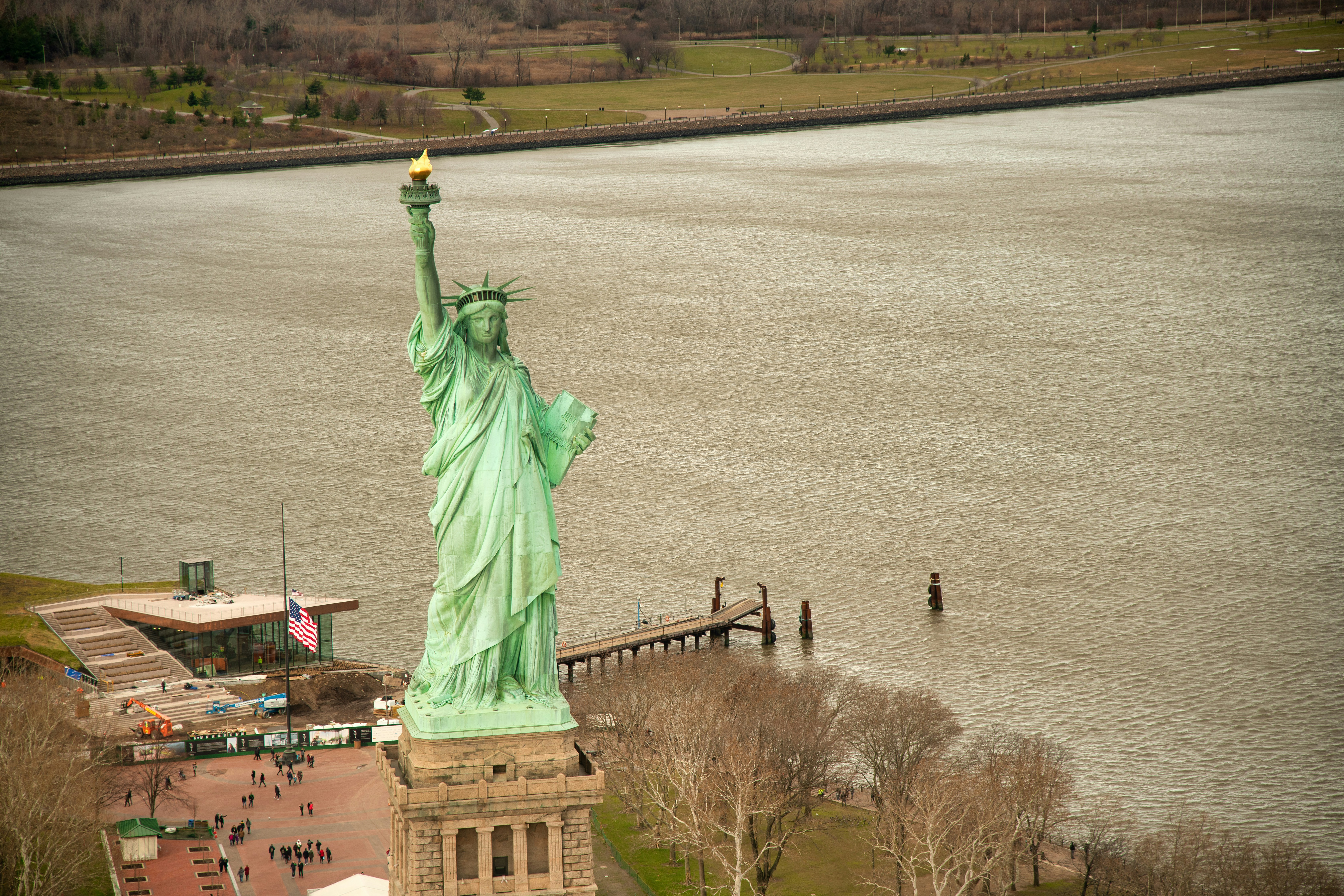 the statue of liberty stands in front of a body of water
