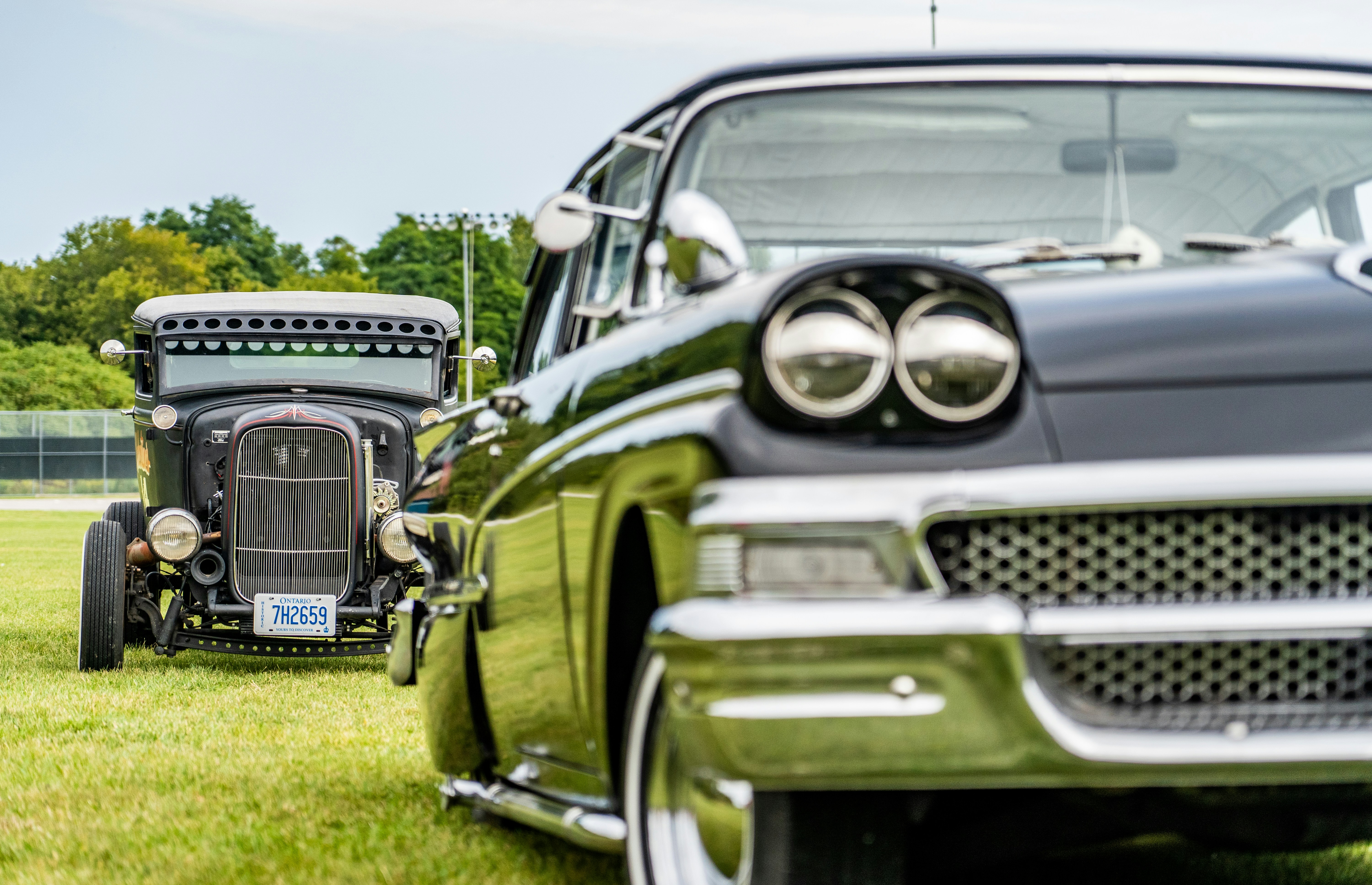 A vintage car and a classic car on display at a car show photo – Free ...