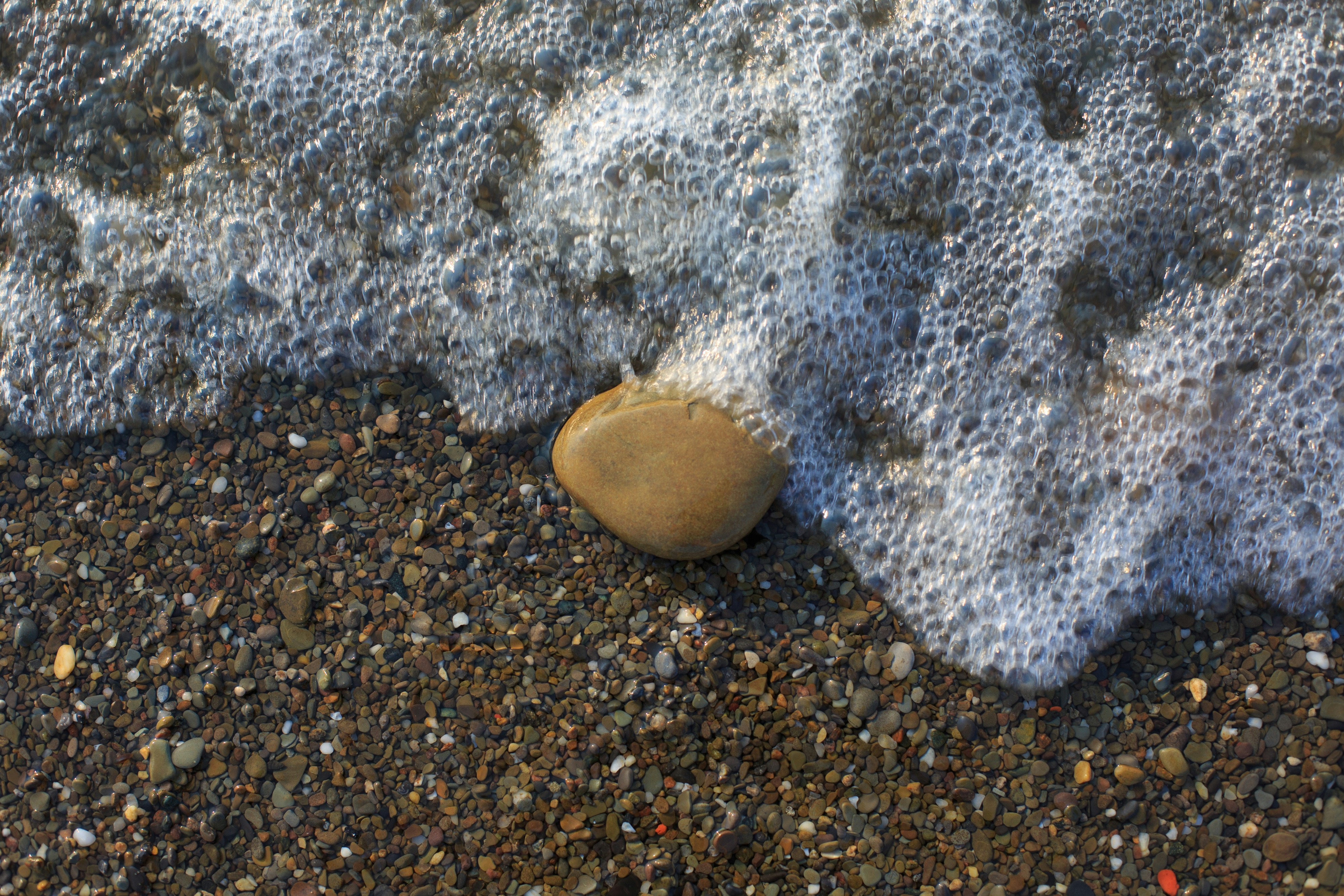 Un rocher assis au sommet d’une plage de sable photo – Photo Rock ...