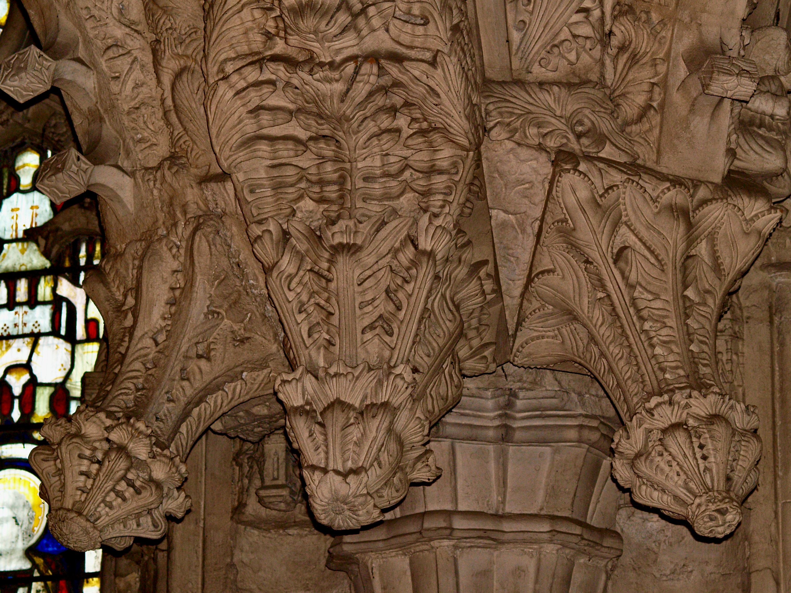Ornate stone carvings depicting mythical creatures and floral designs adorn a cathedral's interior. The artistry reflects the skill and creativity of medieval artisans.