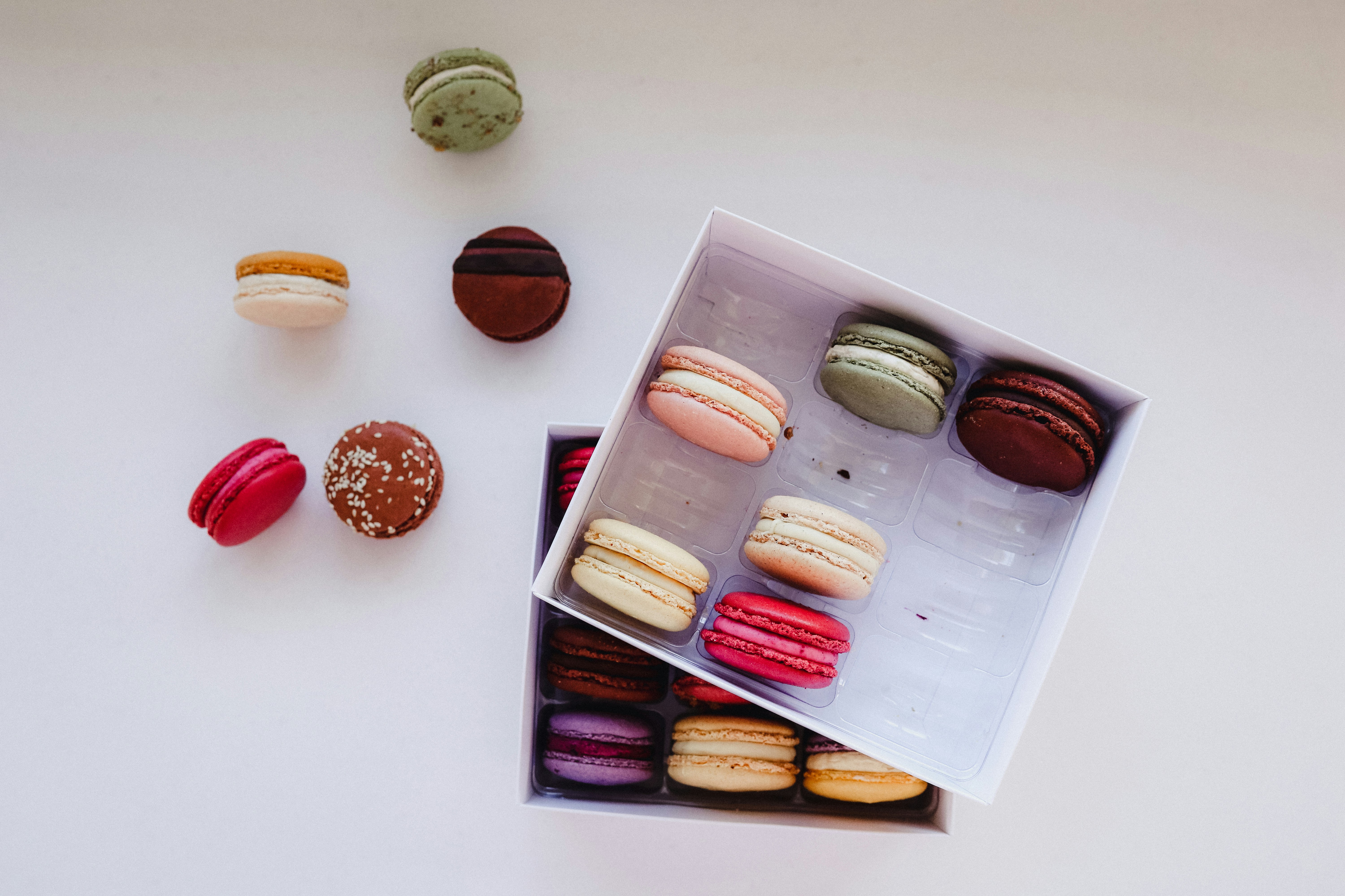 a box of assorted macaroons sitting on a tablemae black