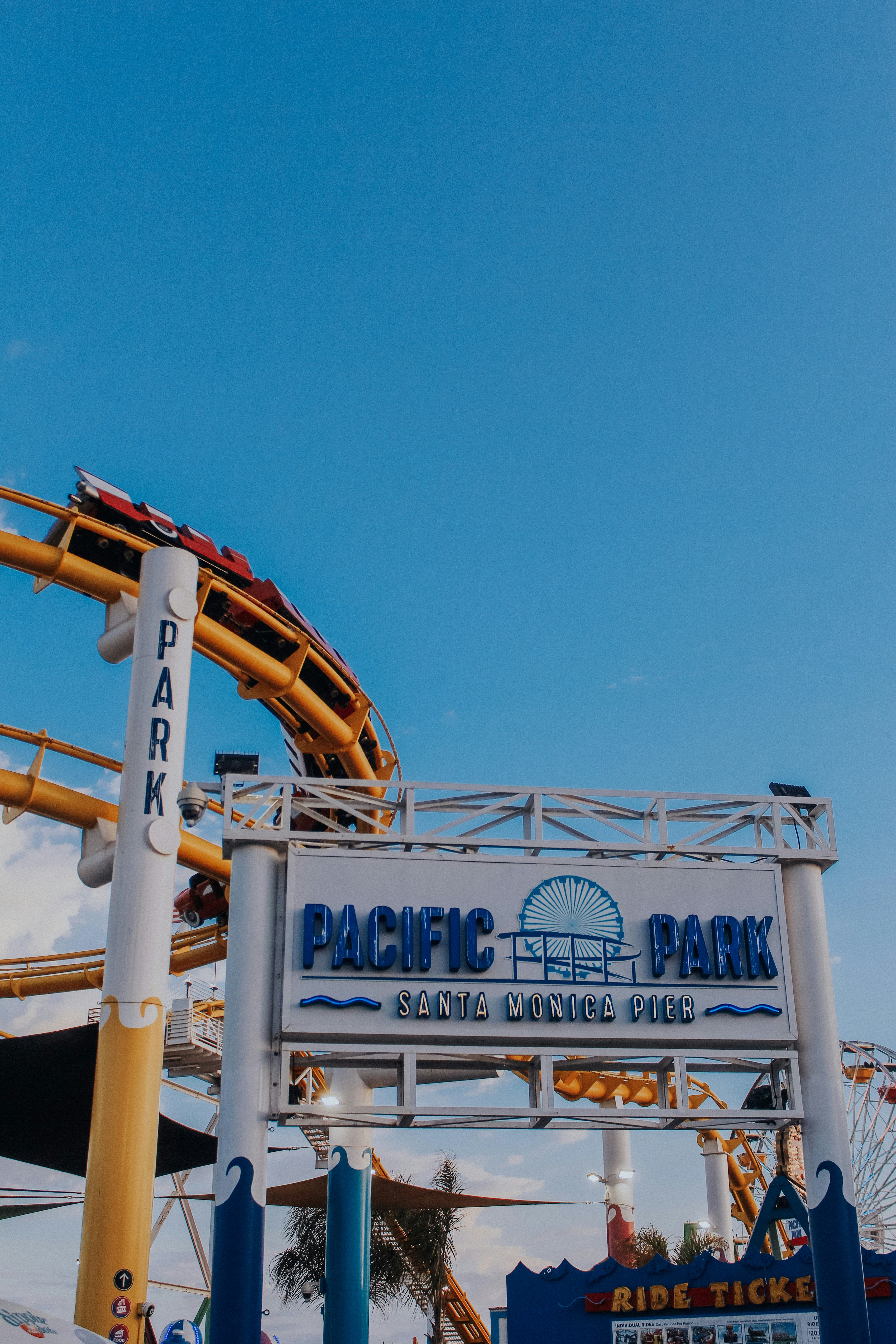 Arc of the Yellow Coaster Over Santa Monica's Pacific Park Sign