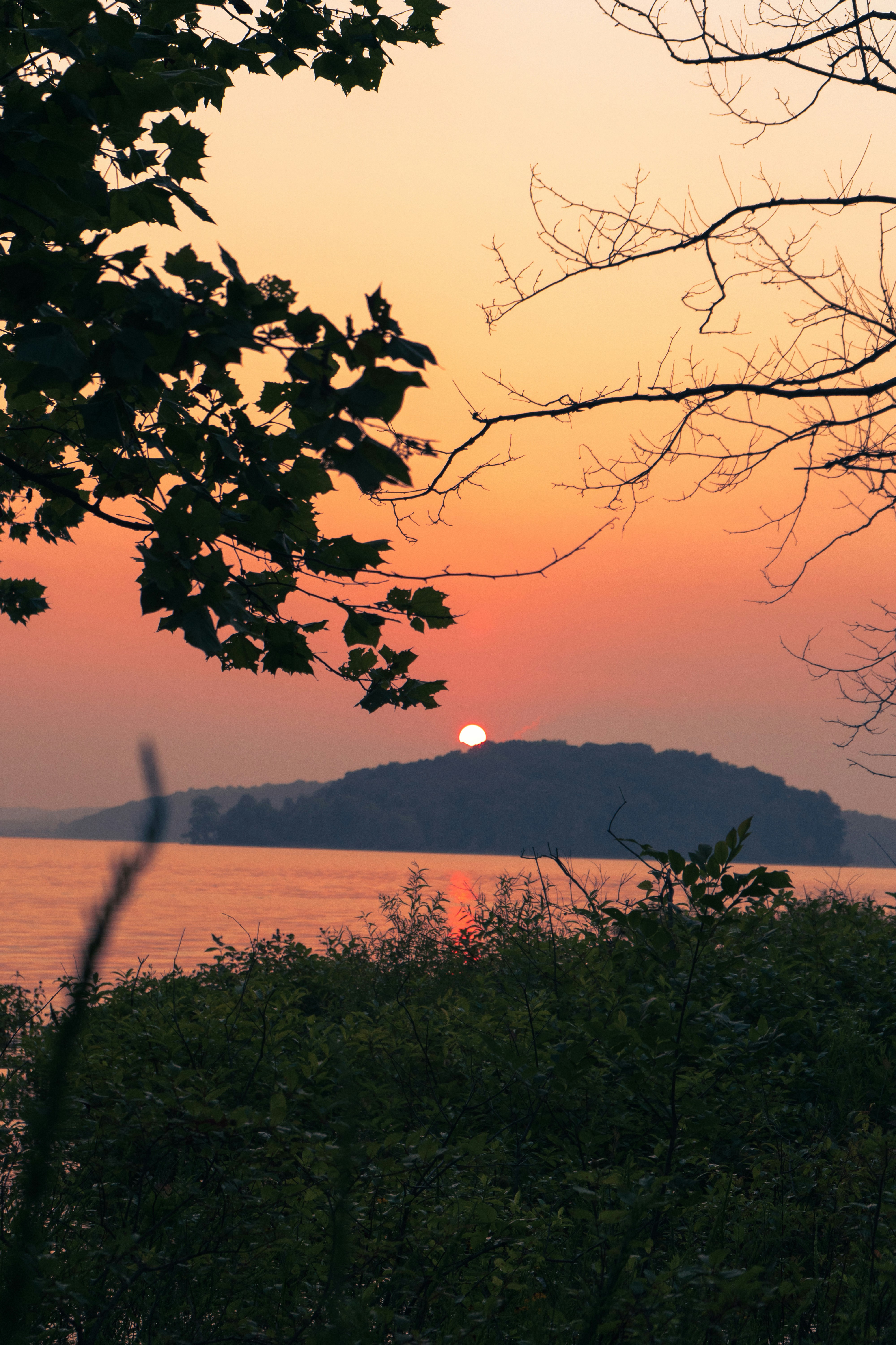 the sun is setting over a body of water