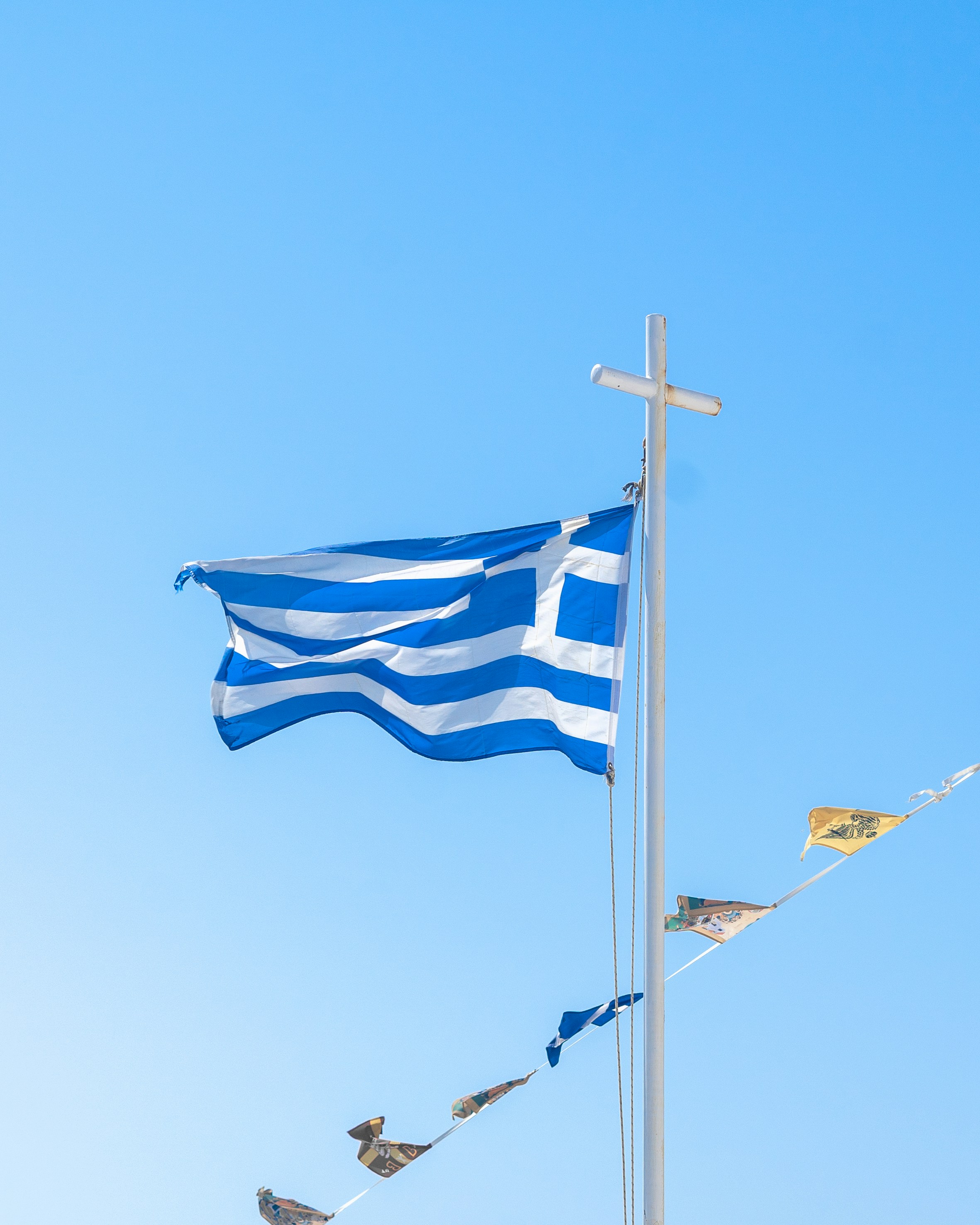 Foto Una bandera azul y blanca ondeando junto a una cruz – Imagen Paros ...