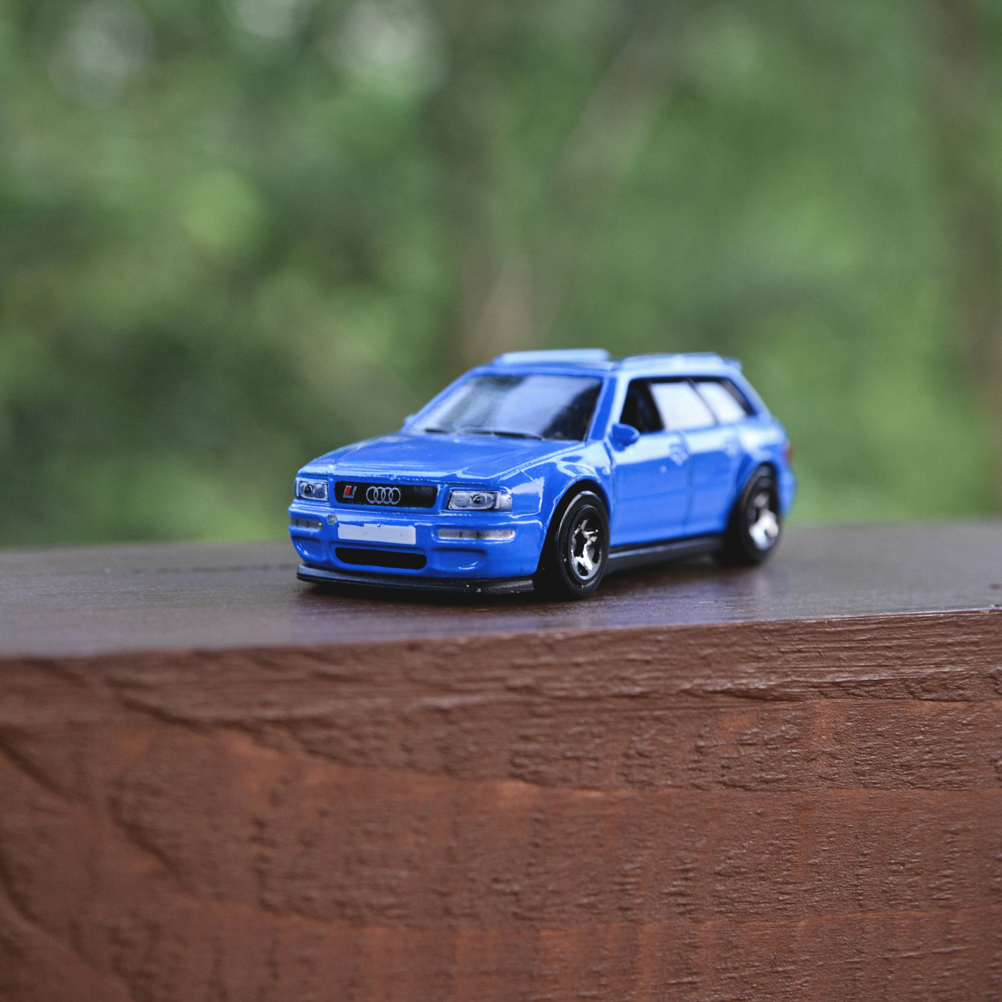 a blue toy car sitting on top of a wooden table