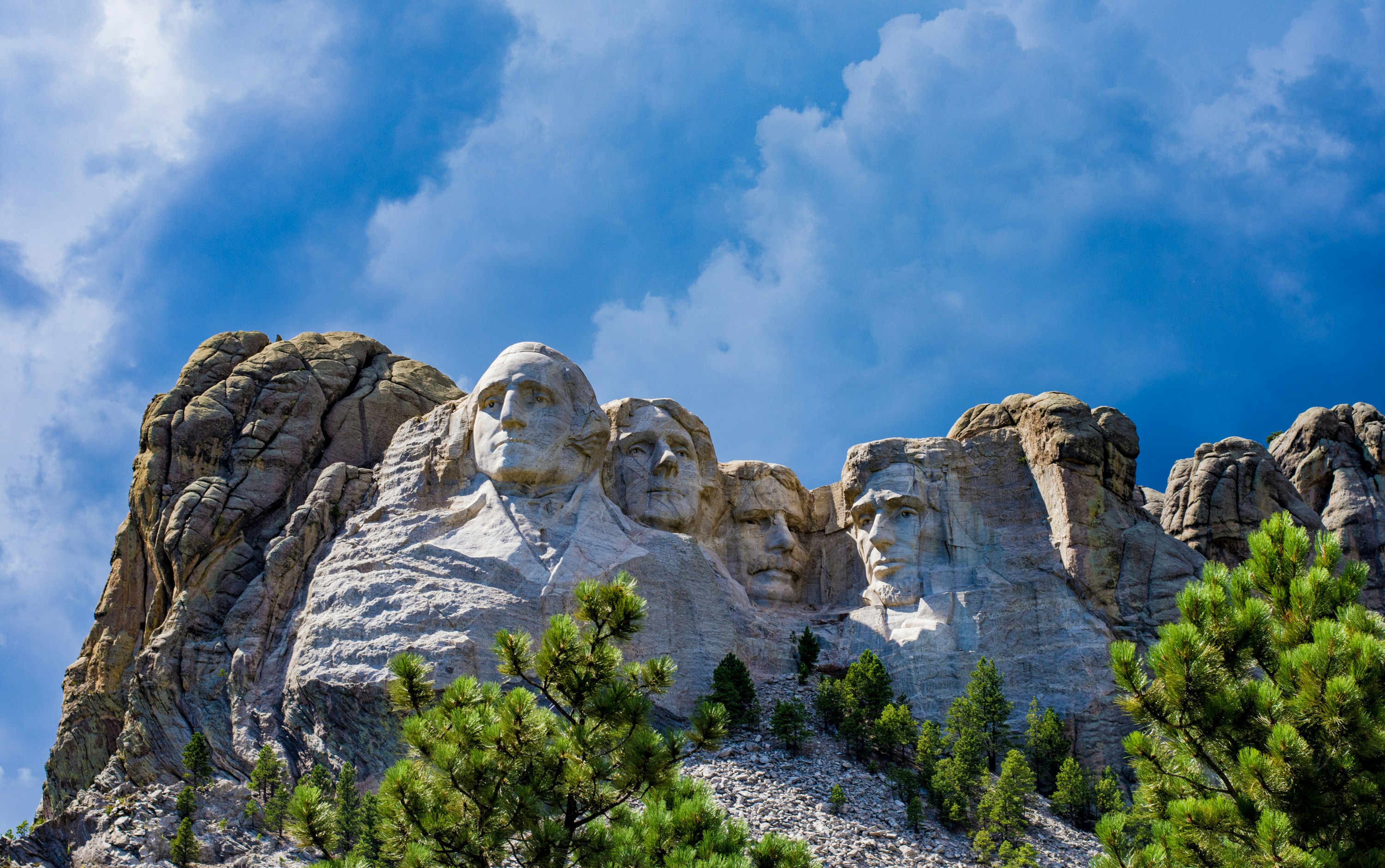 Stone Monolith Summit: Faces in Granite Beneath a Blue Skies Fold