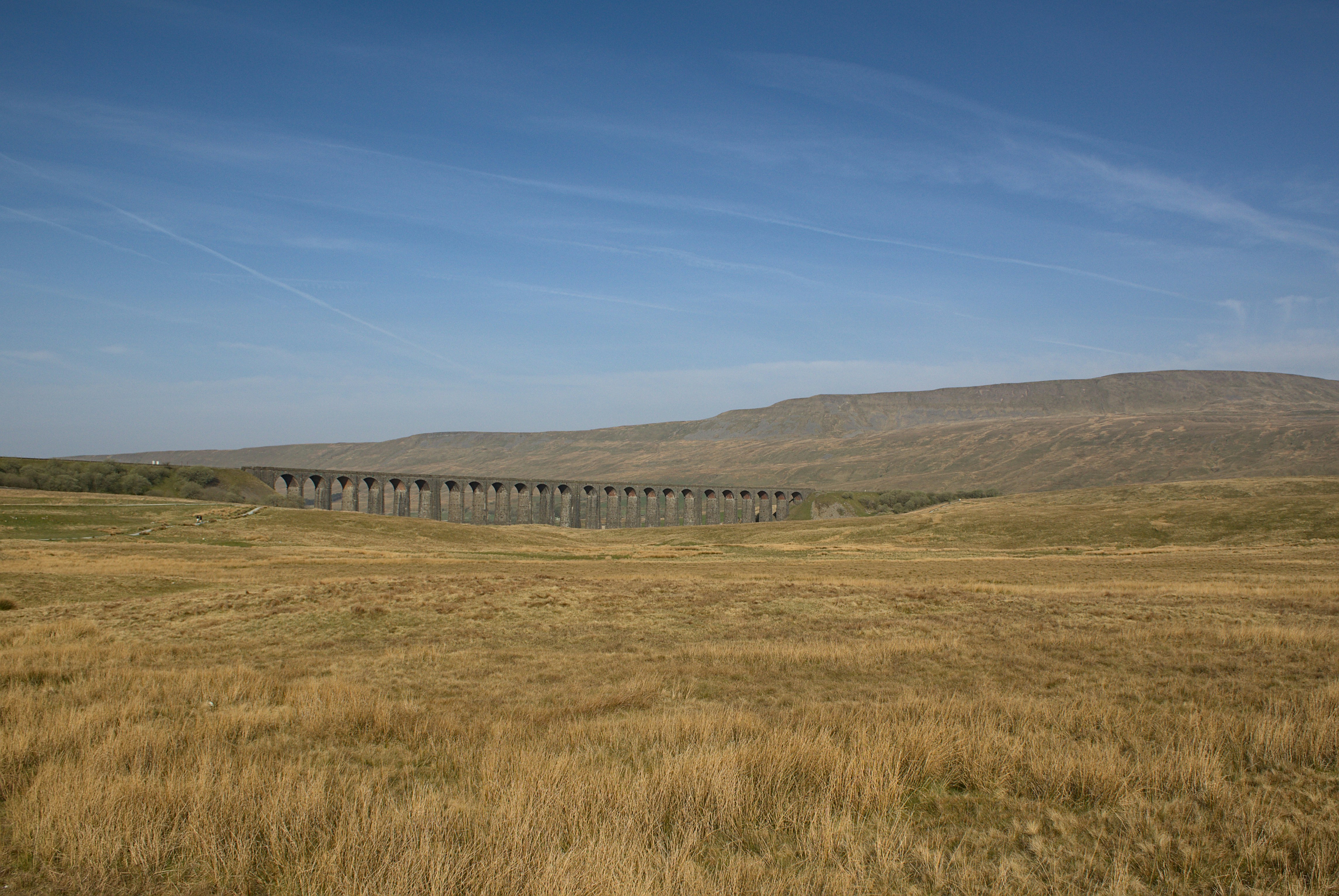 Arched Viaduct Crossing a Golden Prairie Under a Clear Sky