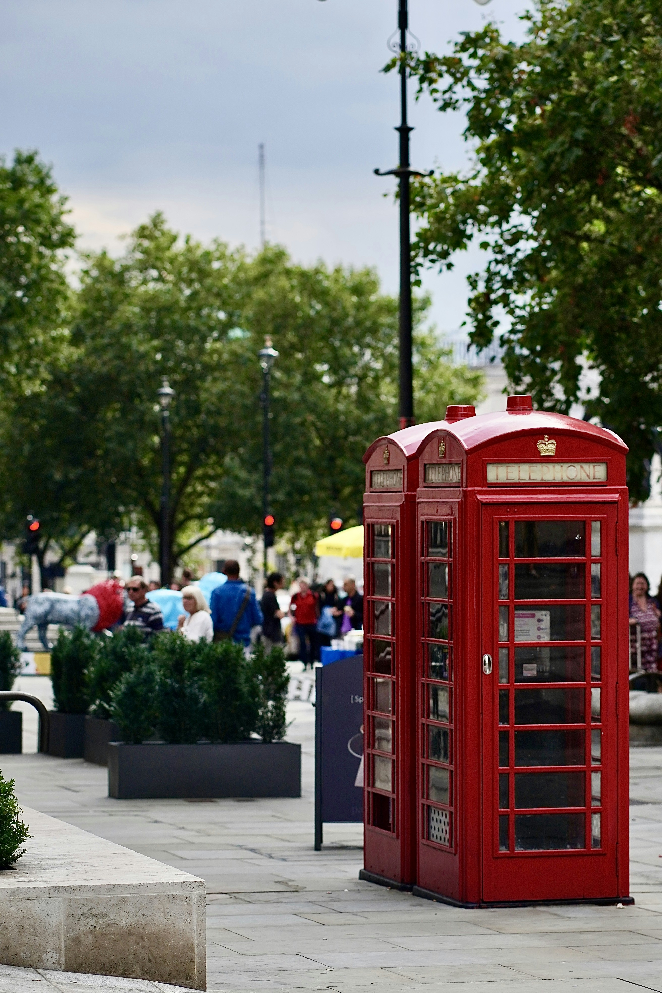 a couple of red telephone booths sitting on the side of a road