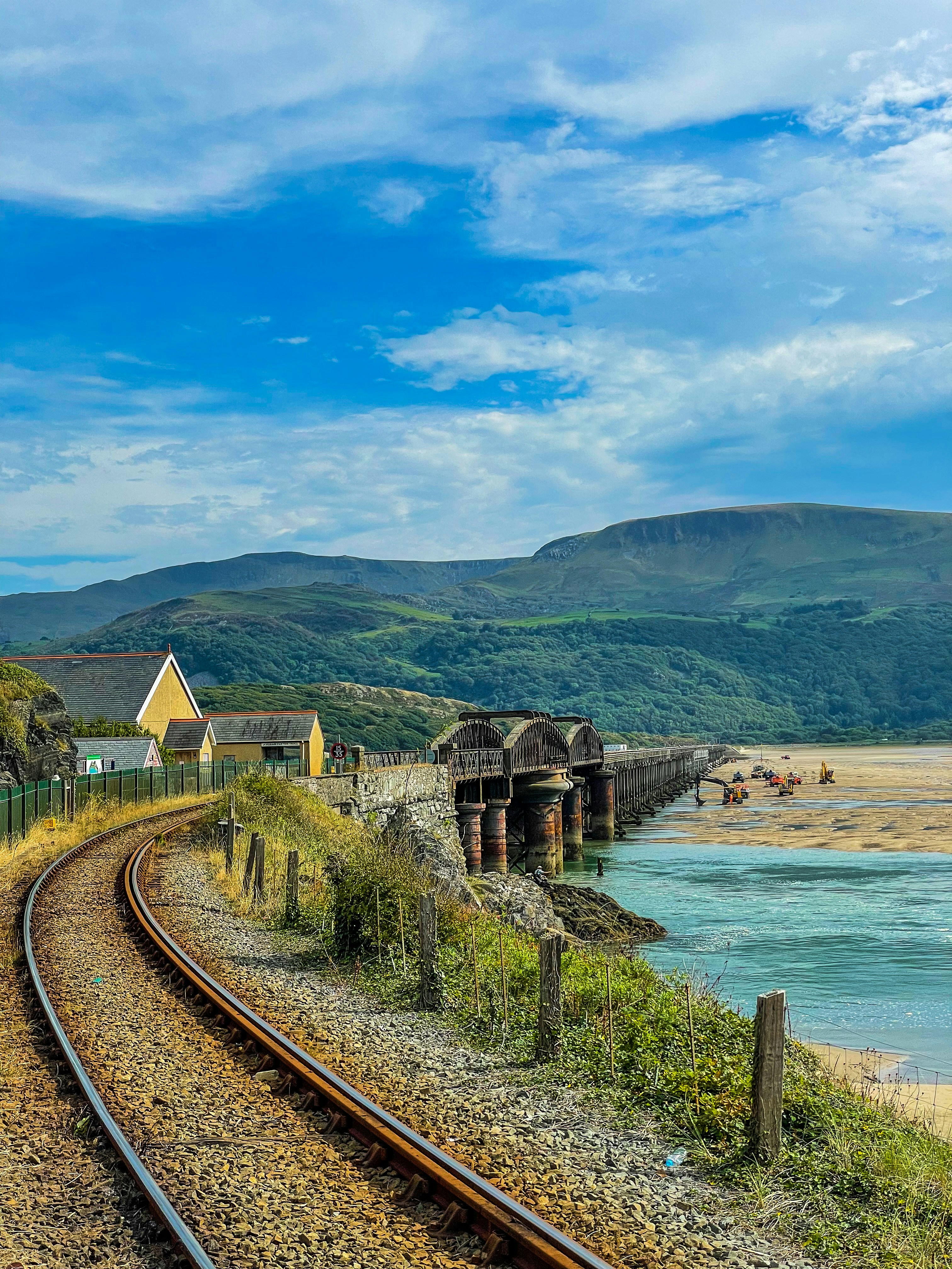 A train track running alongside a body of water photo – Free Barmouth ...