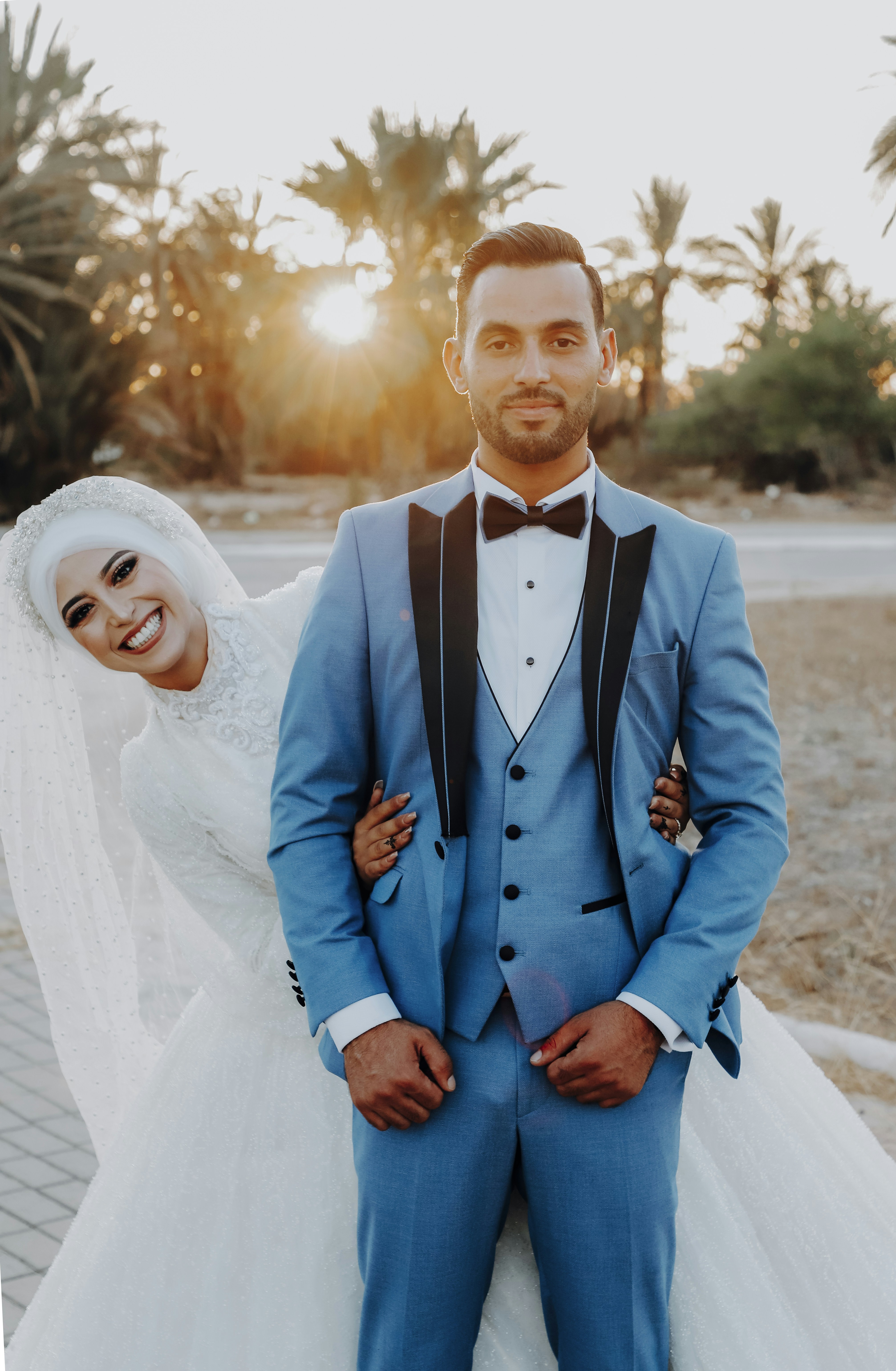 A bride and groom pose for a photo in front of palm trees photo – Free ...