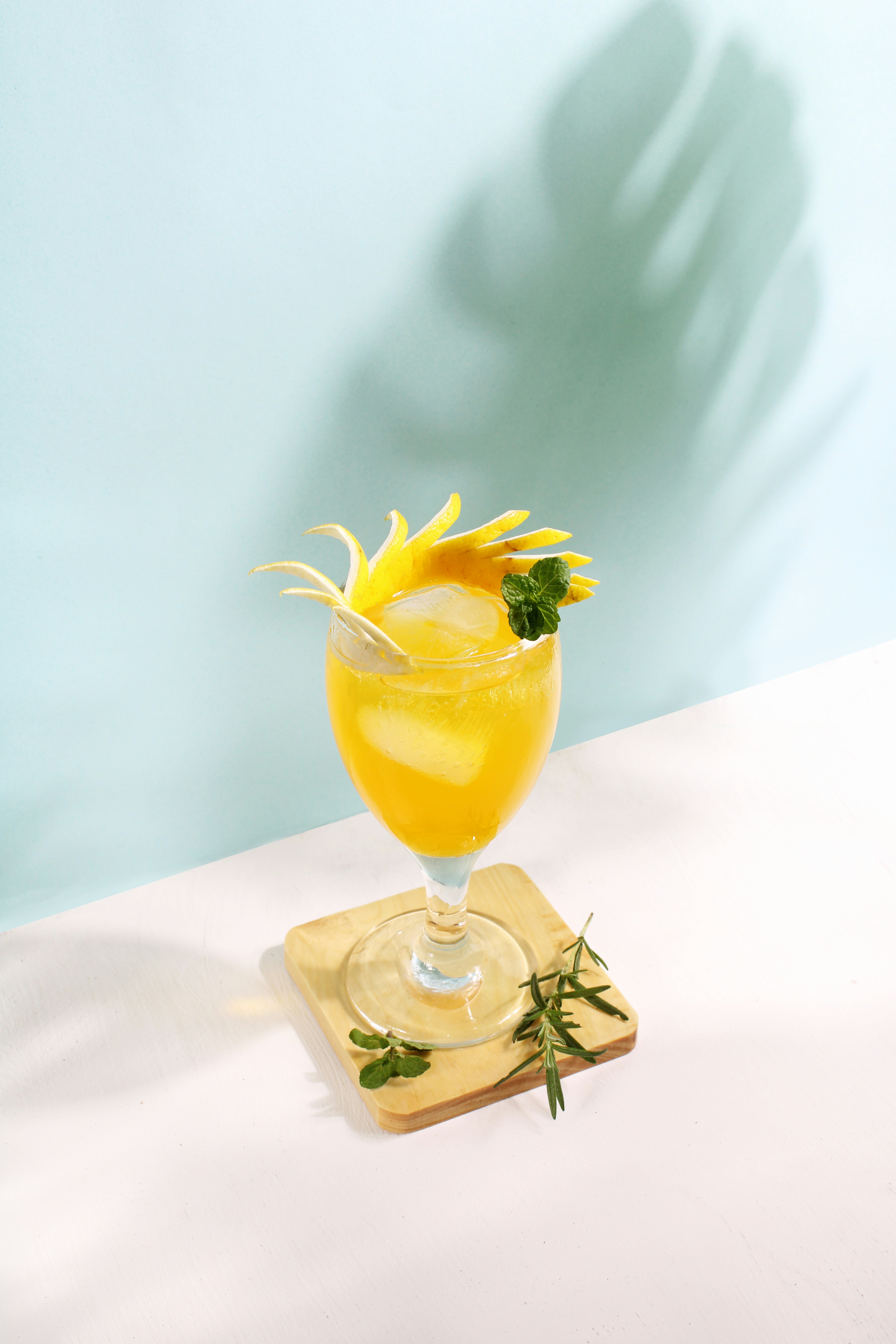 A glass of lemonade with a garnish on a coaster photo – Free Beverage ...