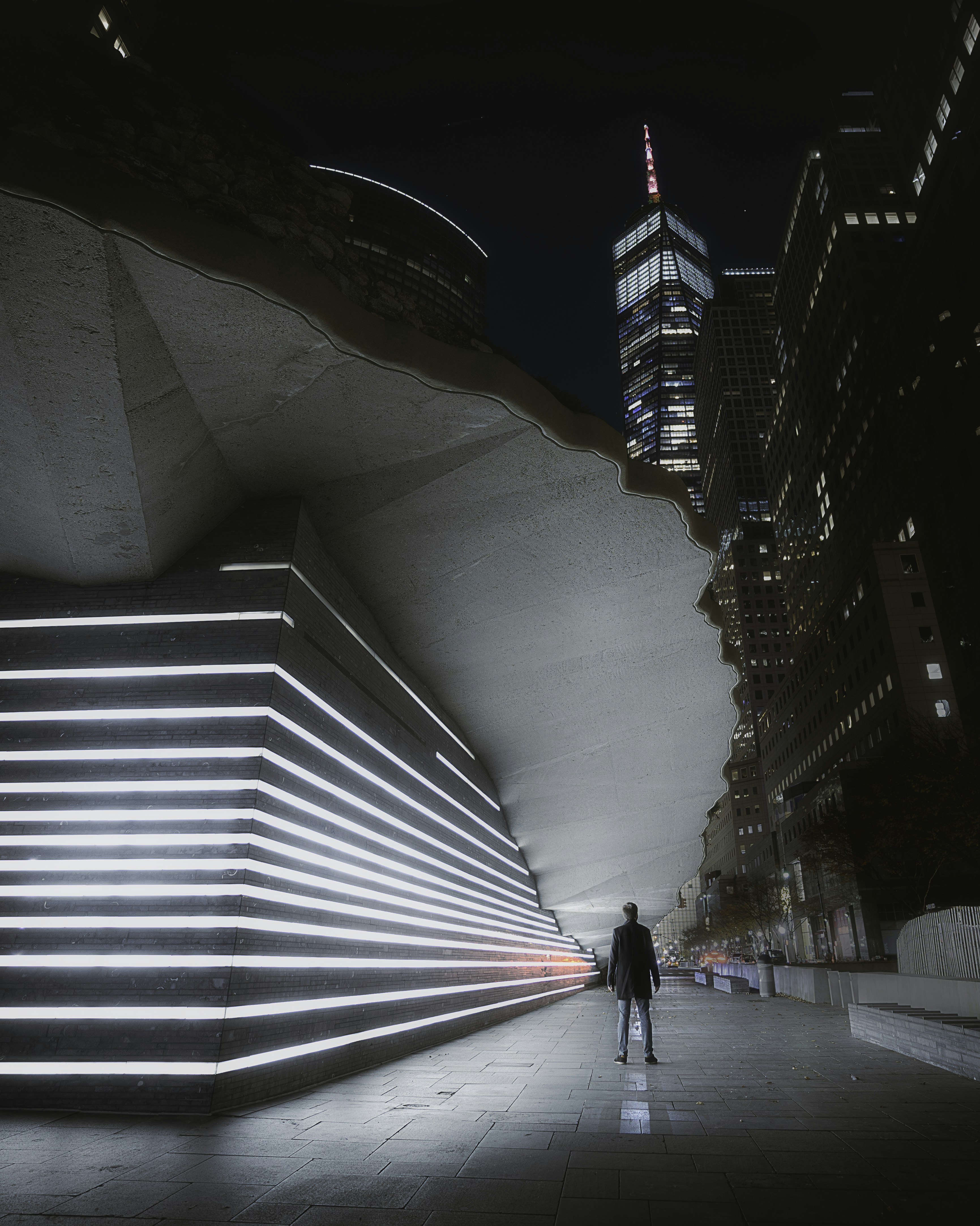 A man walking down a street next to tall buildings photo – Free ...