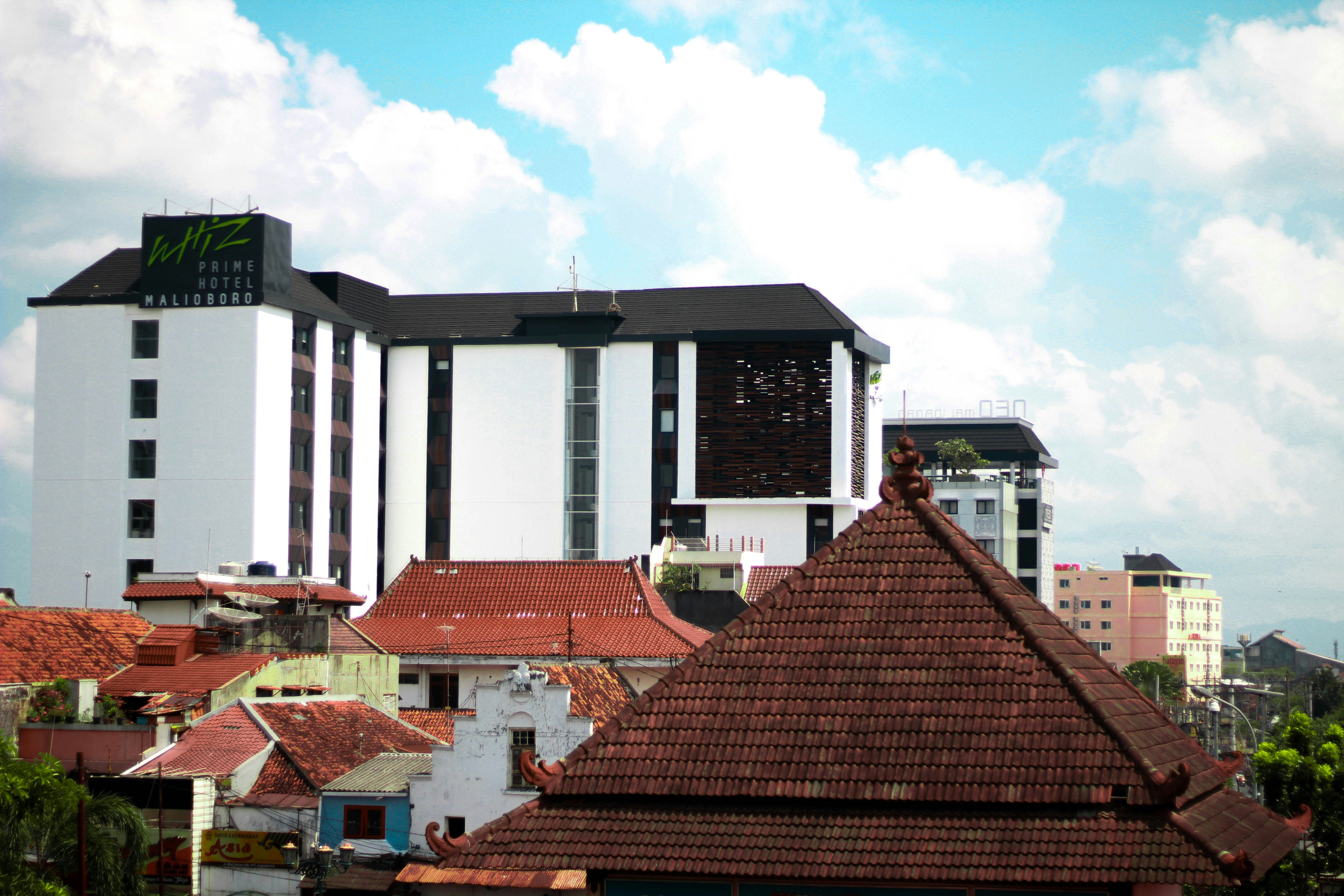 Red Roof Ridge Framing a Modern Skyline