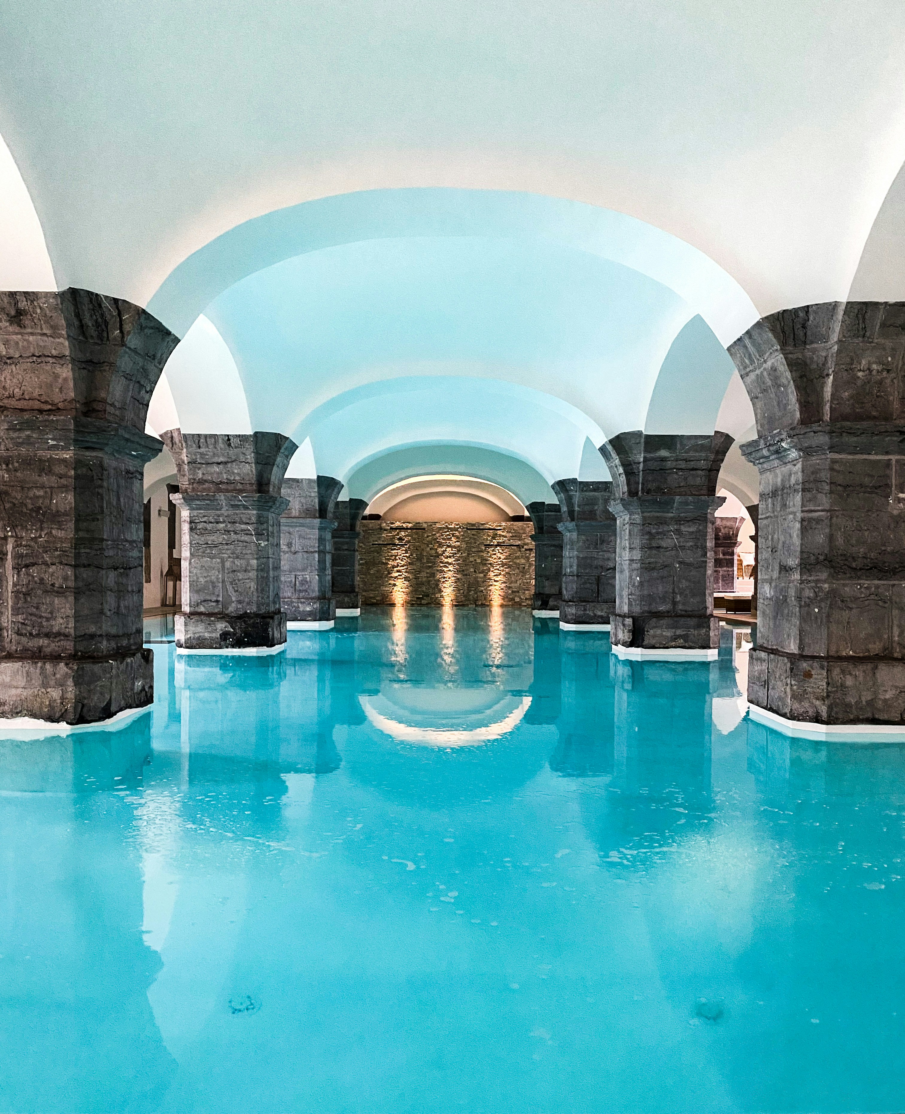 a large indoor swimming pool with blue water