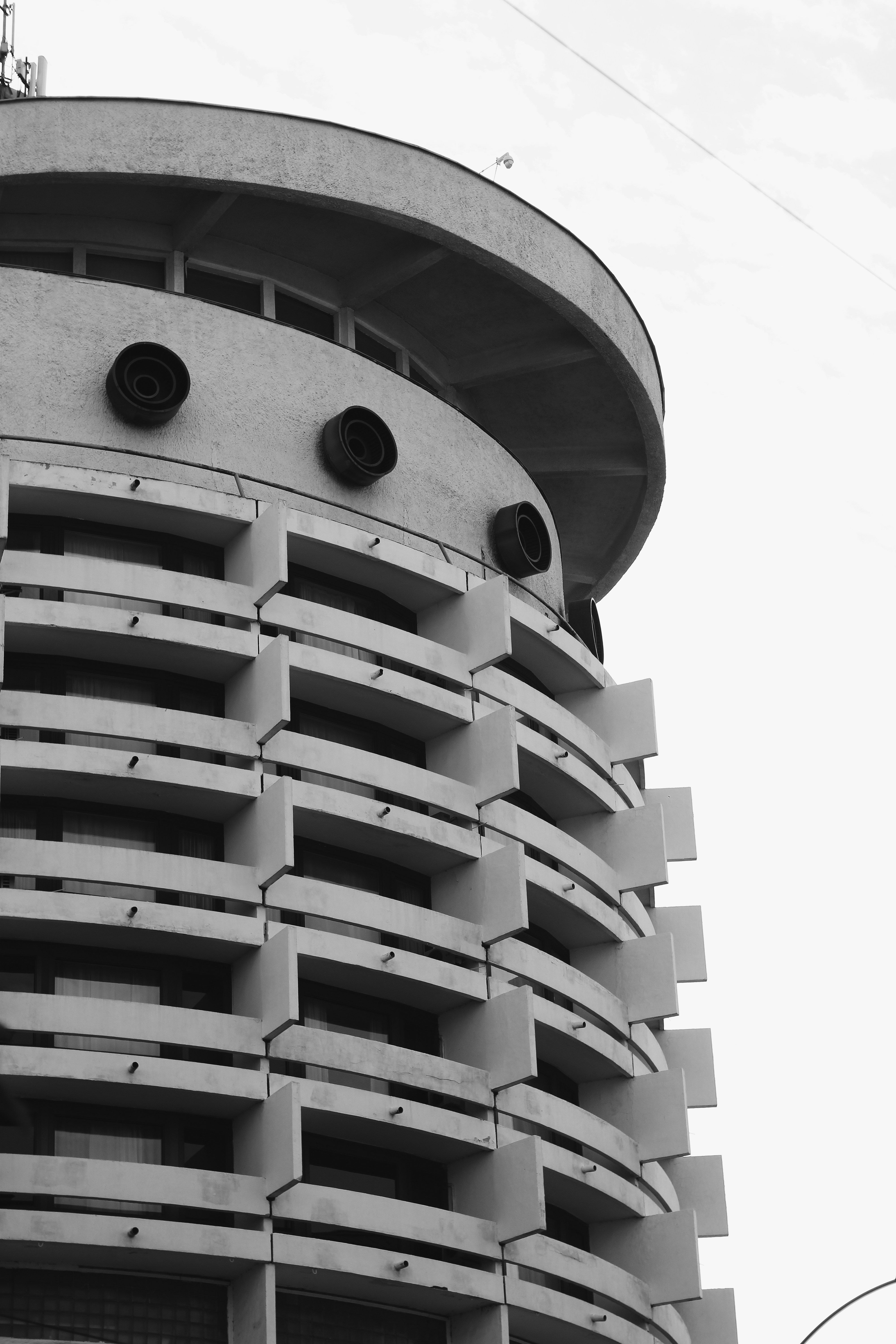 Modernist building showcasing a spiral design with prominent circular features and geometric patterns in monochrome.
