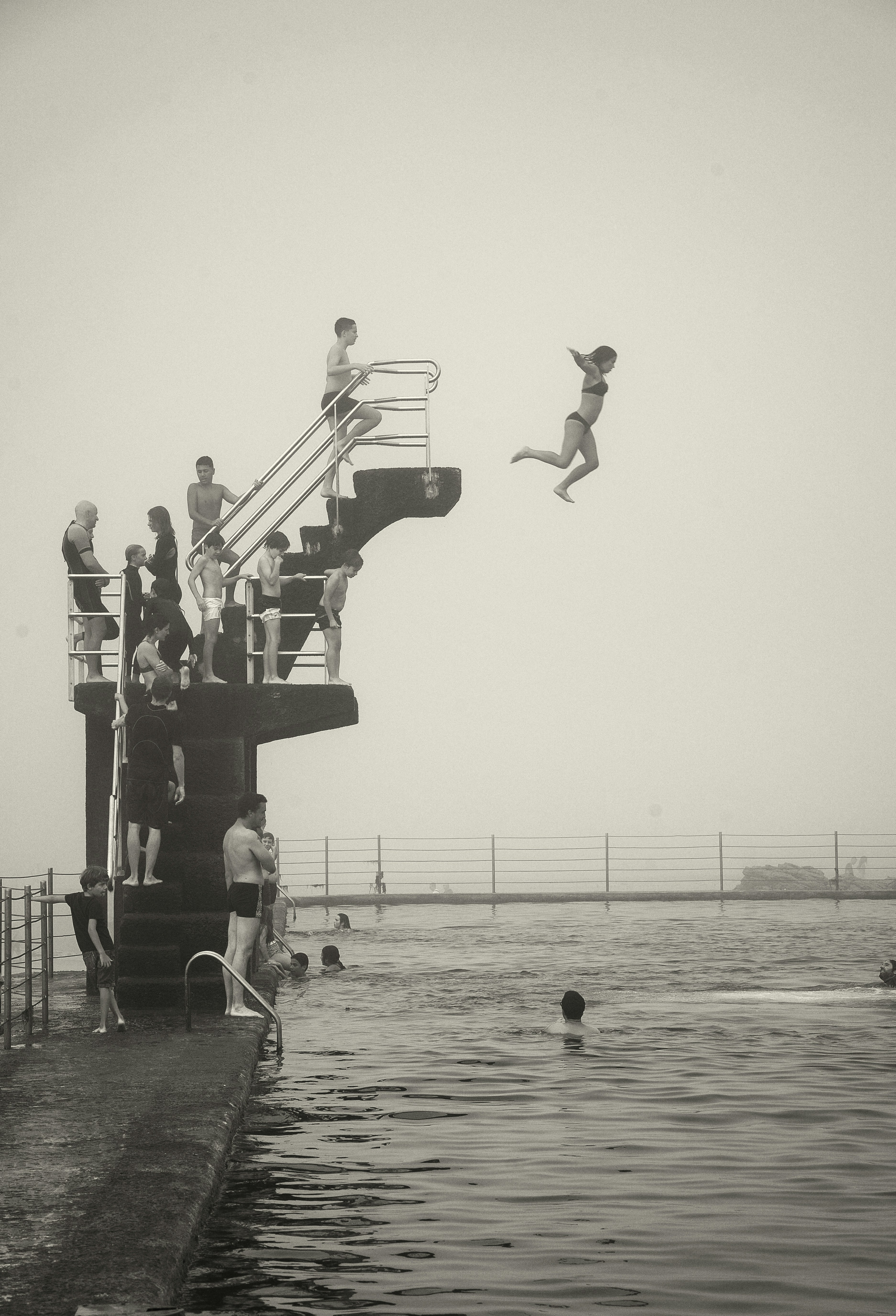 A group of people jumping off a boat into a body of water photo – Free ...