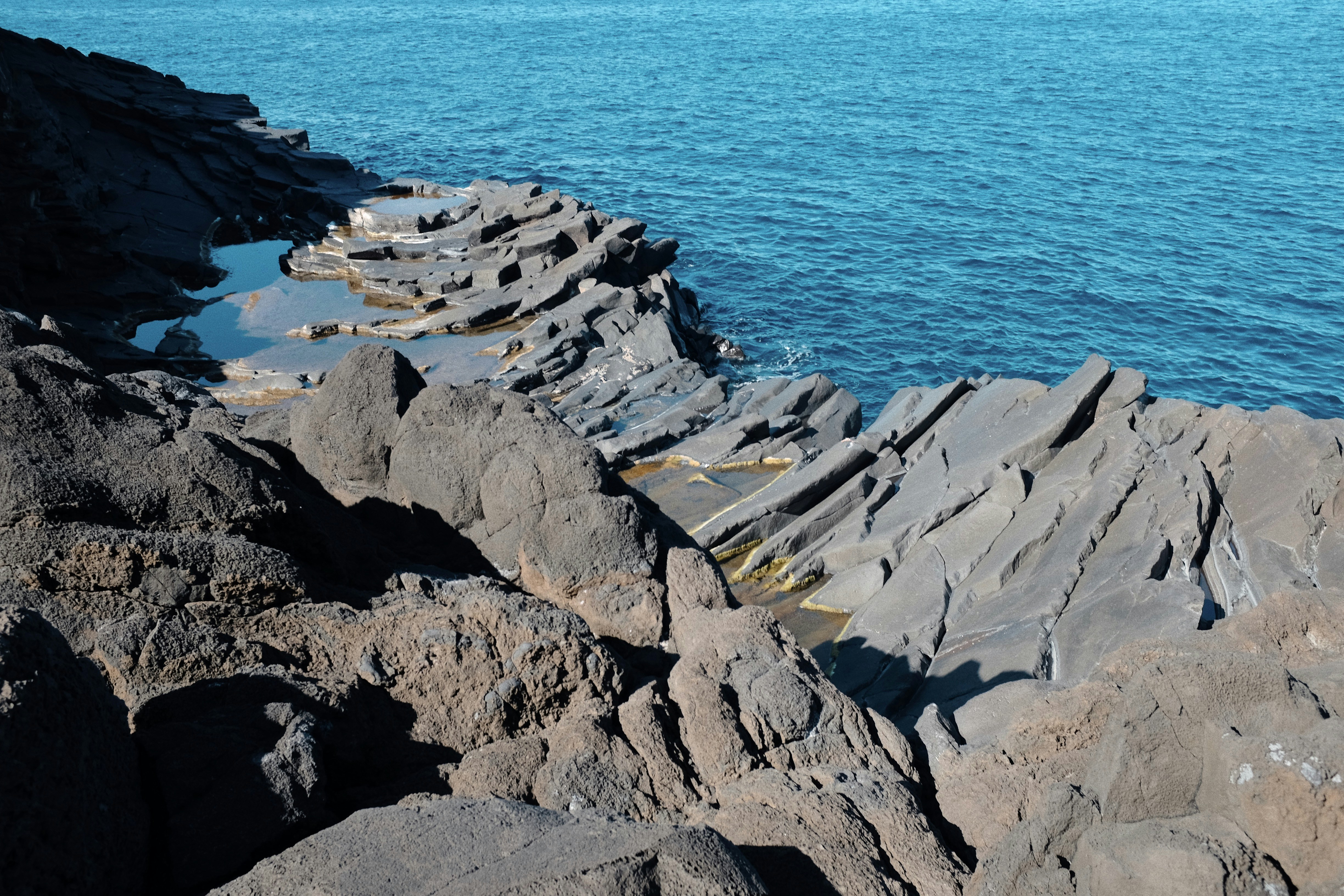 A line of rocks sitting on top of a rocky beach photo – Free Seixal ...