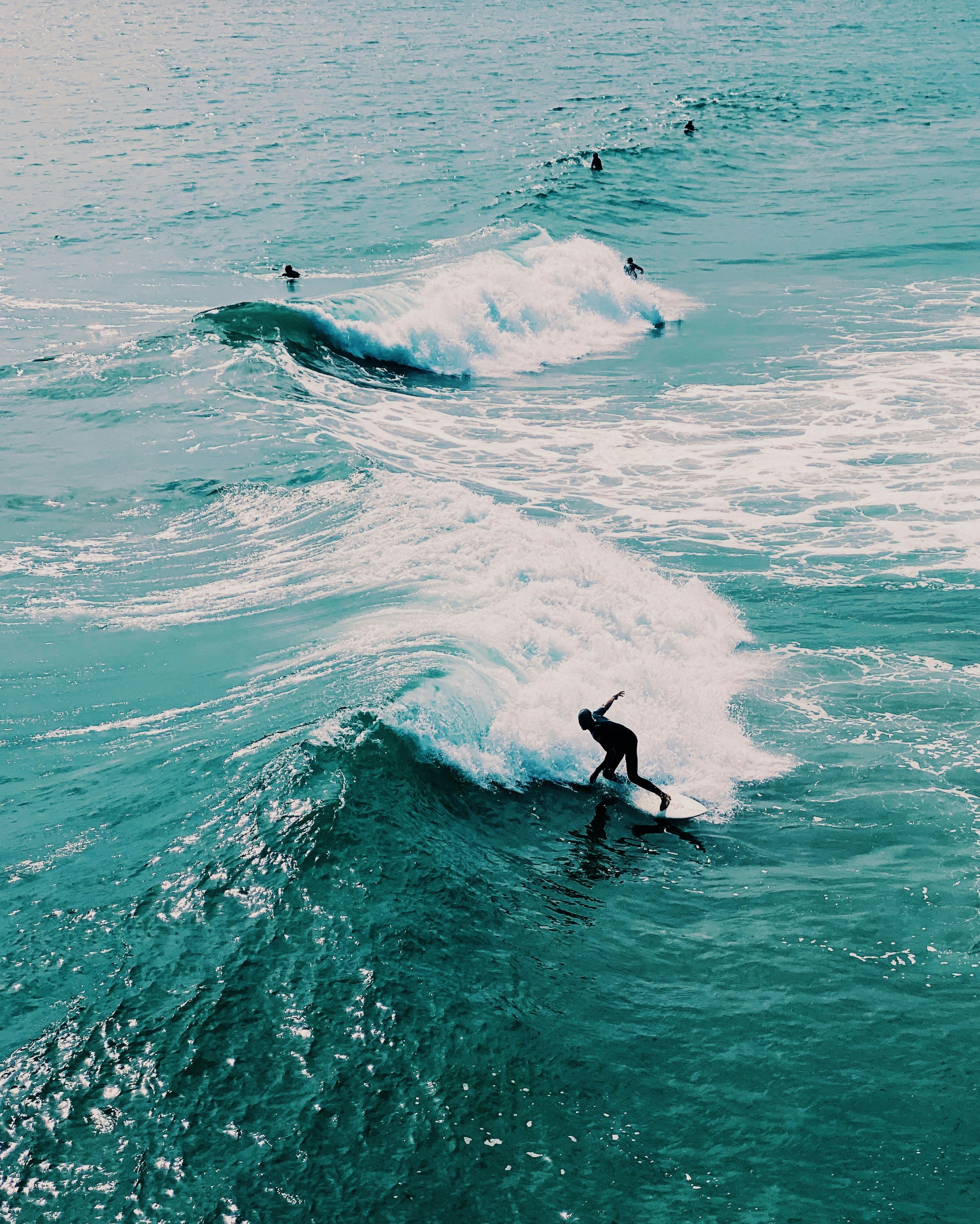Surfer skillfully navigating a wave amidst a vibrant ocean backdrop, capturing the essence of adrenaline and freedom.