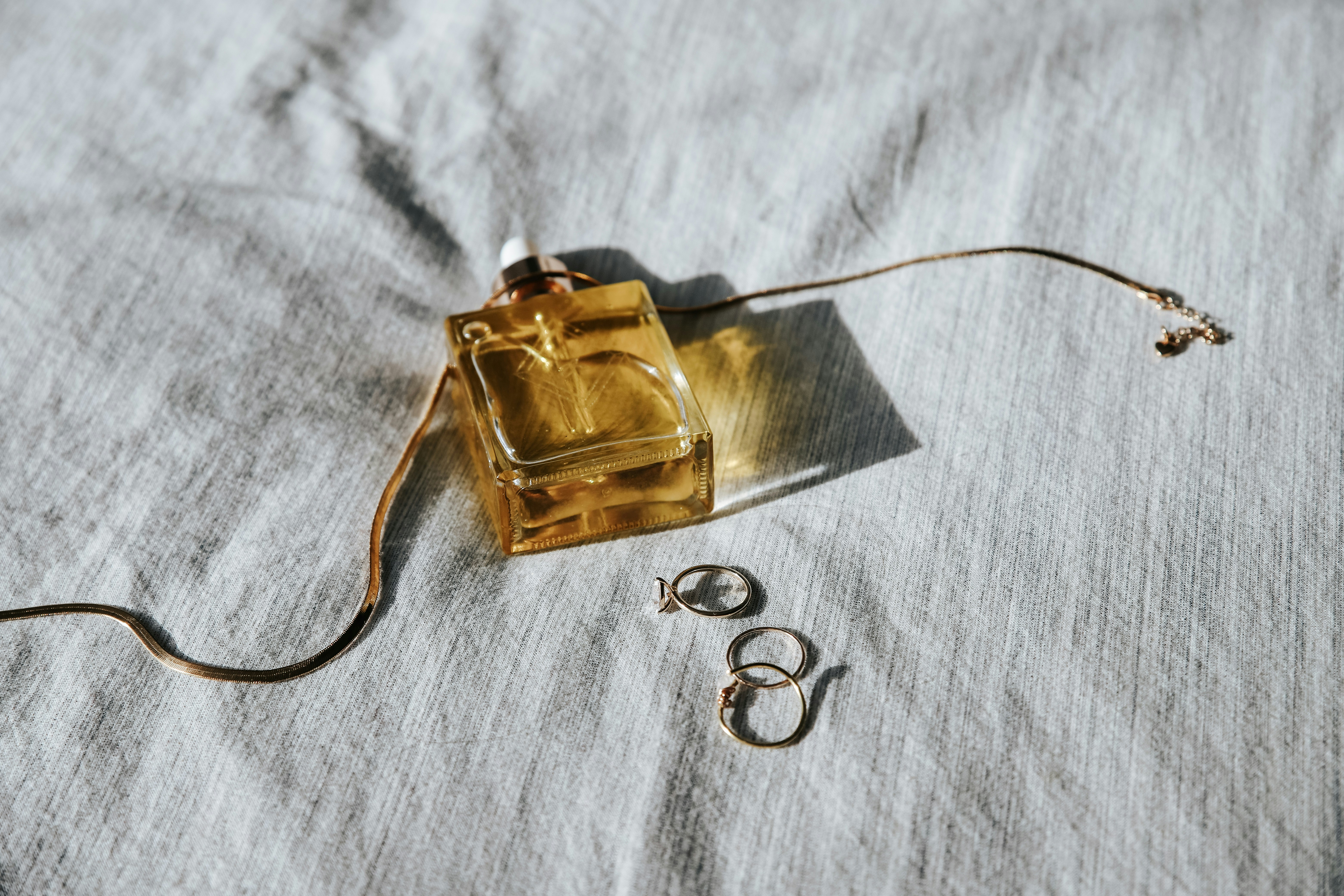 a bottle of perfume sitting on top of a bed