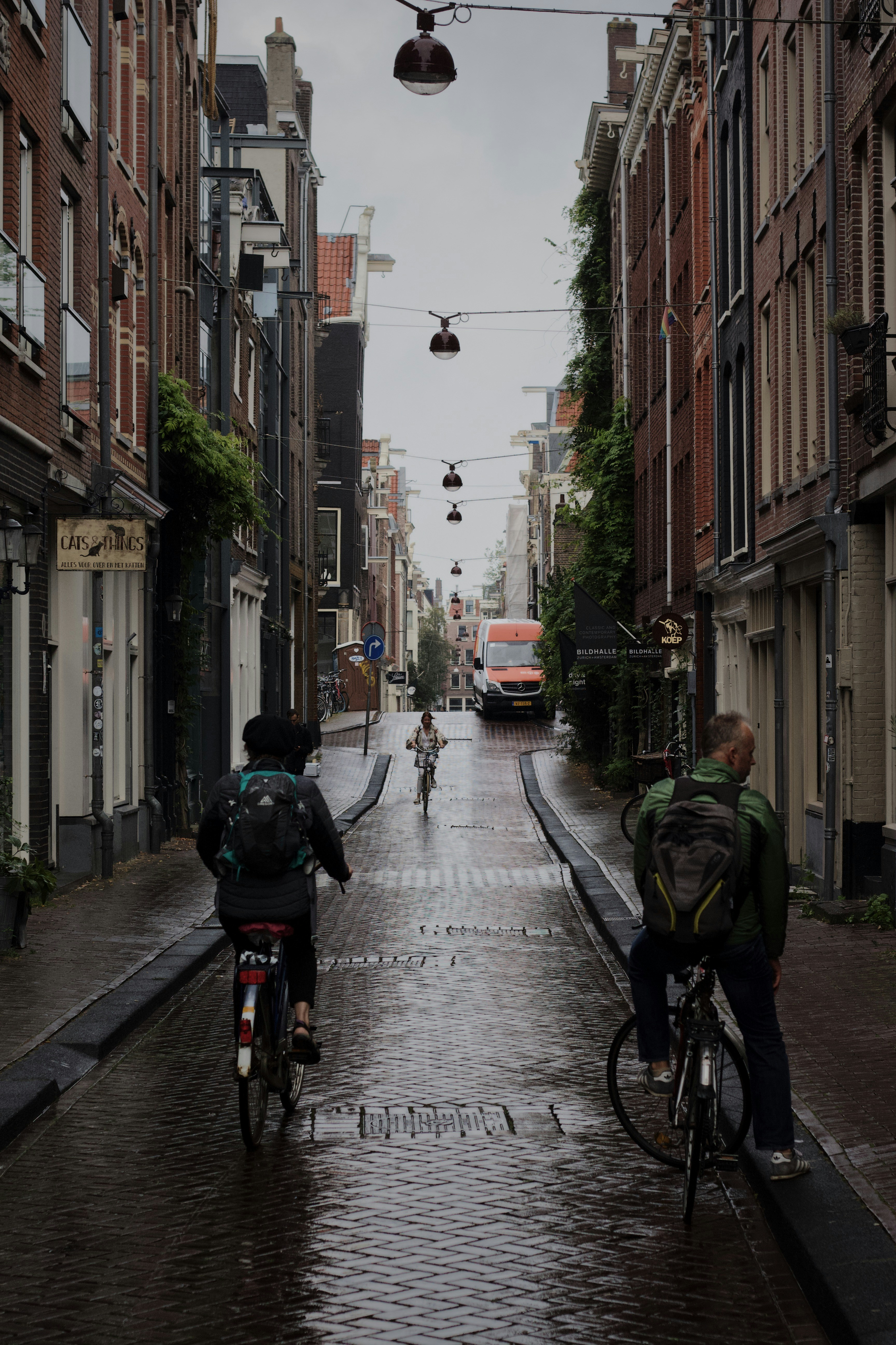 A couple of people riding bikes down a street photo – Free Netherlands ...