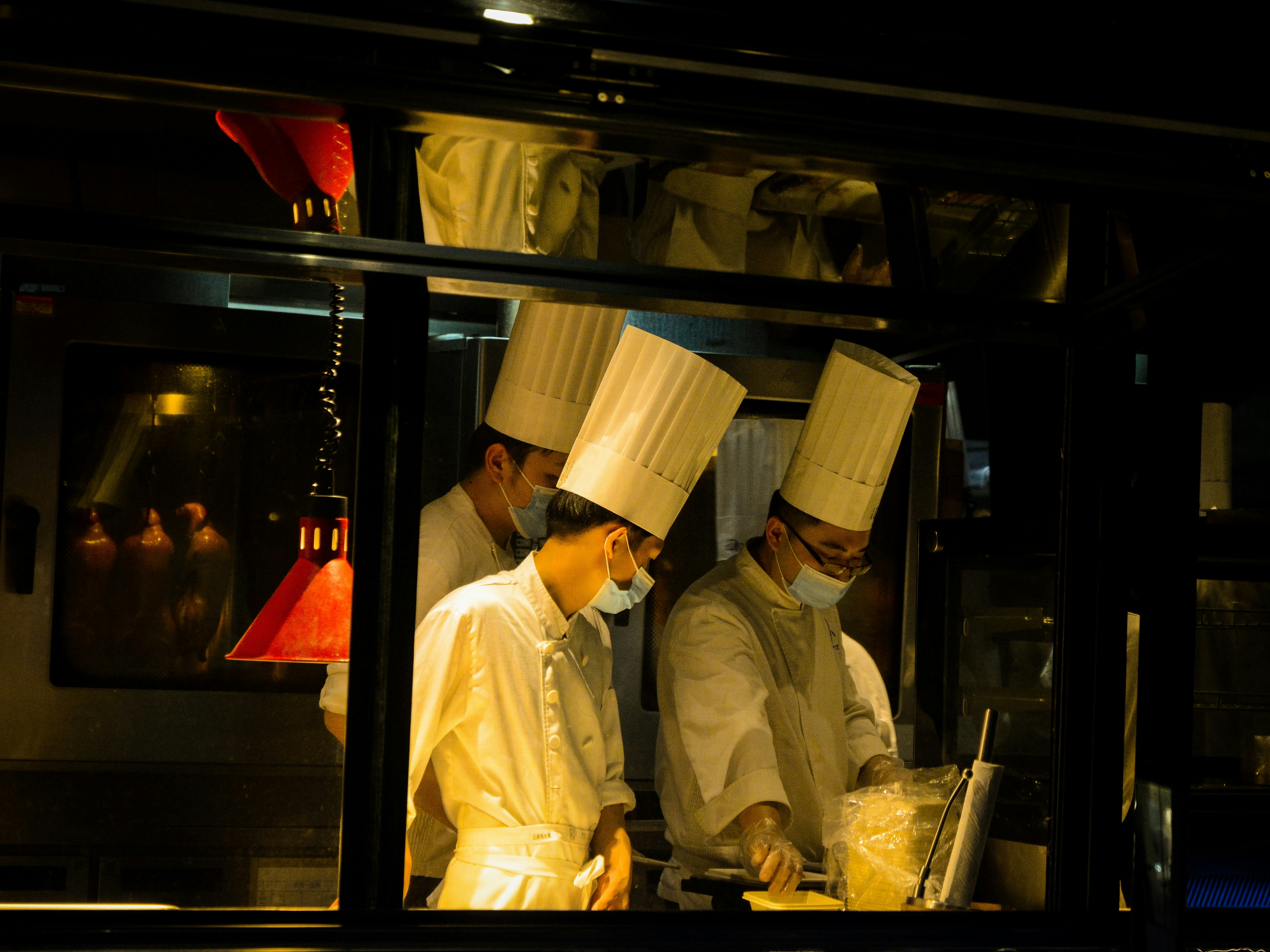 A group of chefs preparing food inside of a kitchen photo – Free Human ...