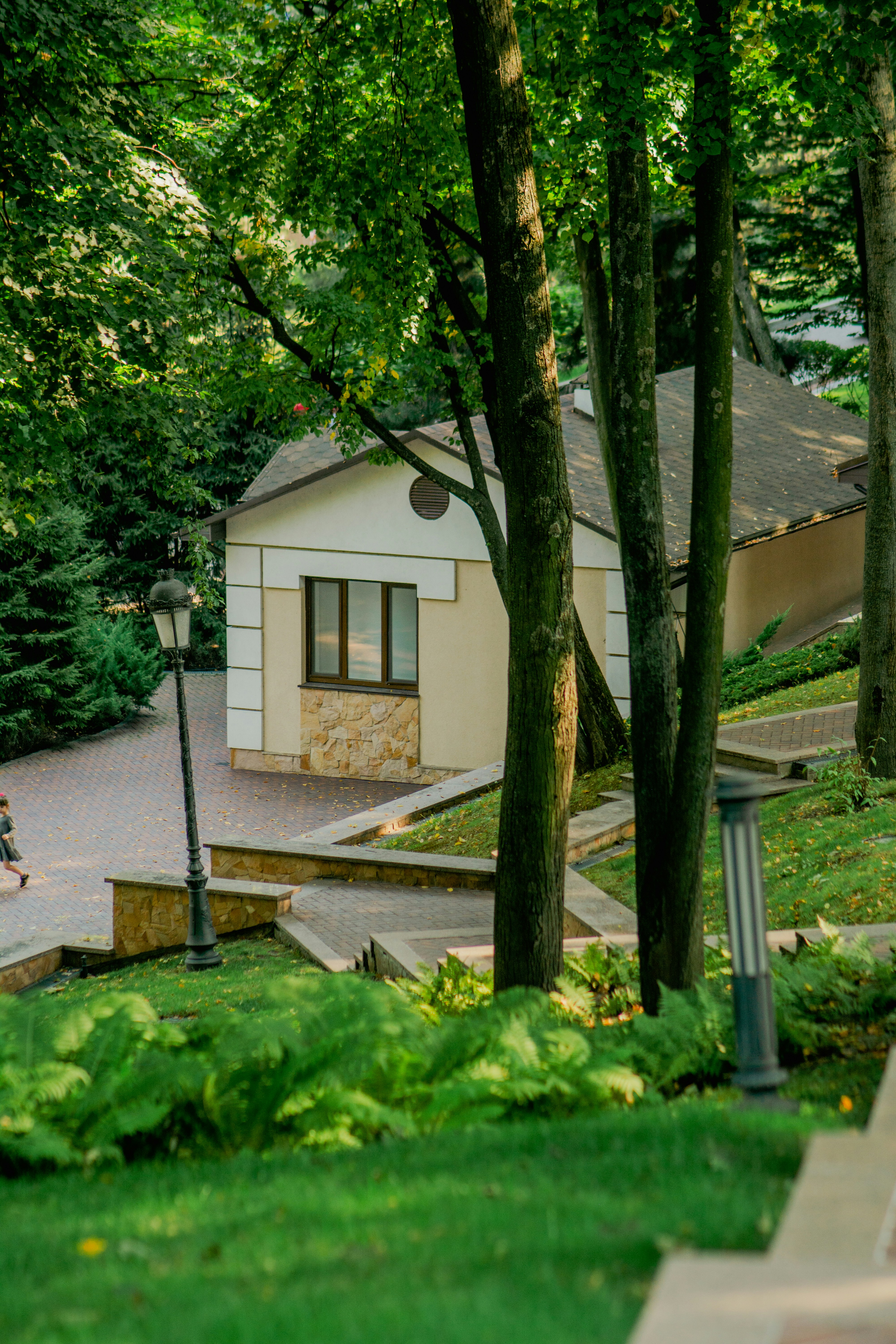 a small white house sitting in the middle of a park