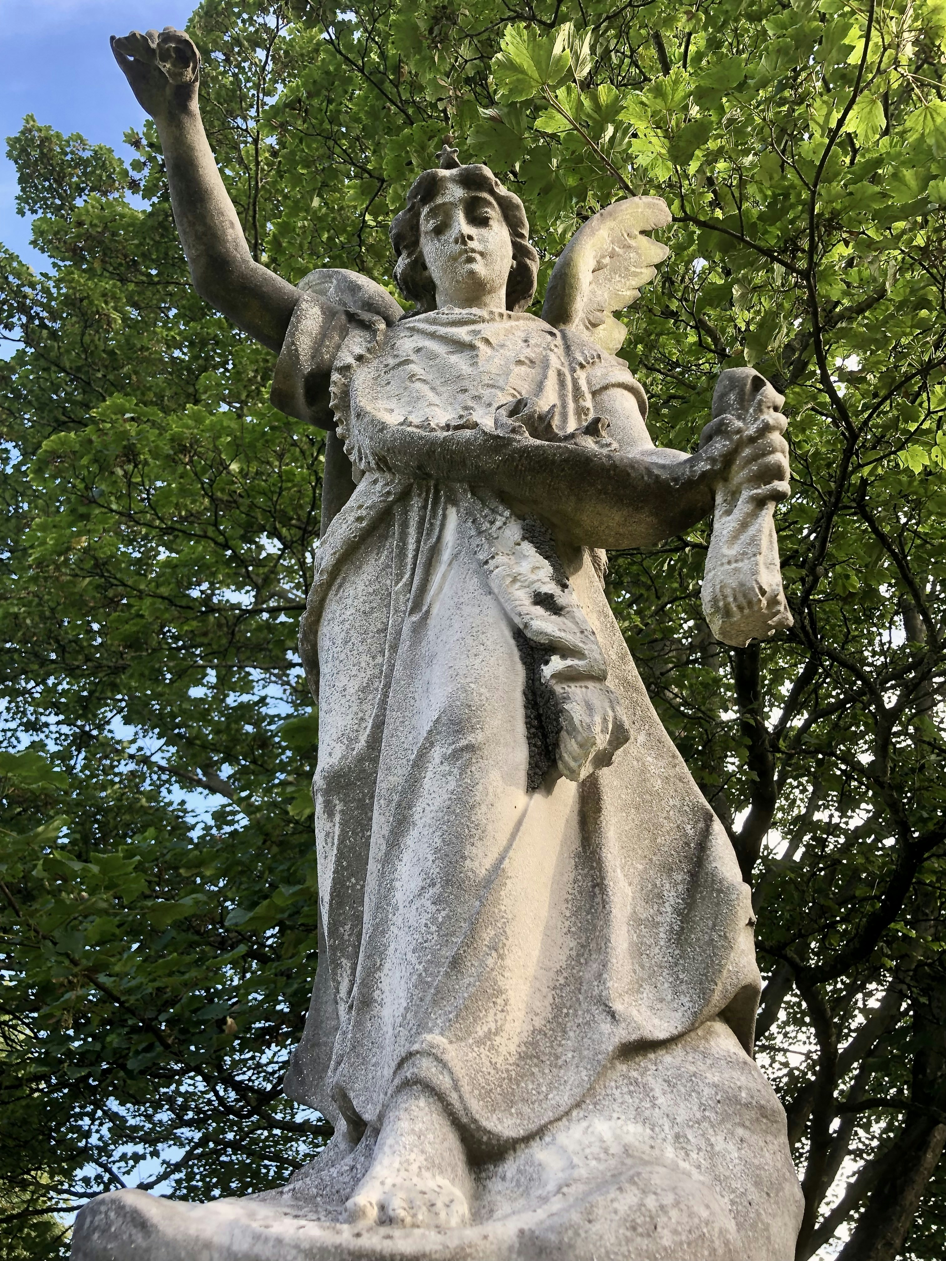 A statue of an angel holding a staff photo – Free Stone Image on Unsplash