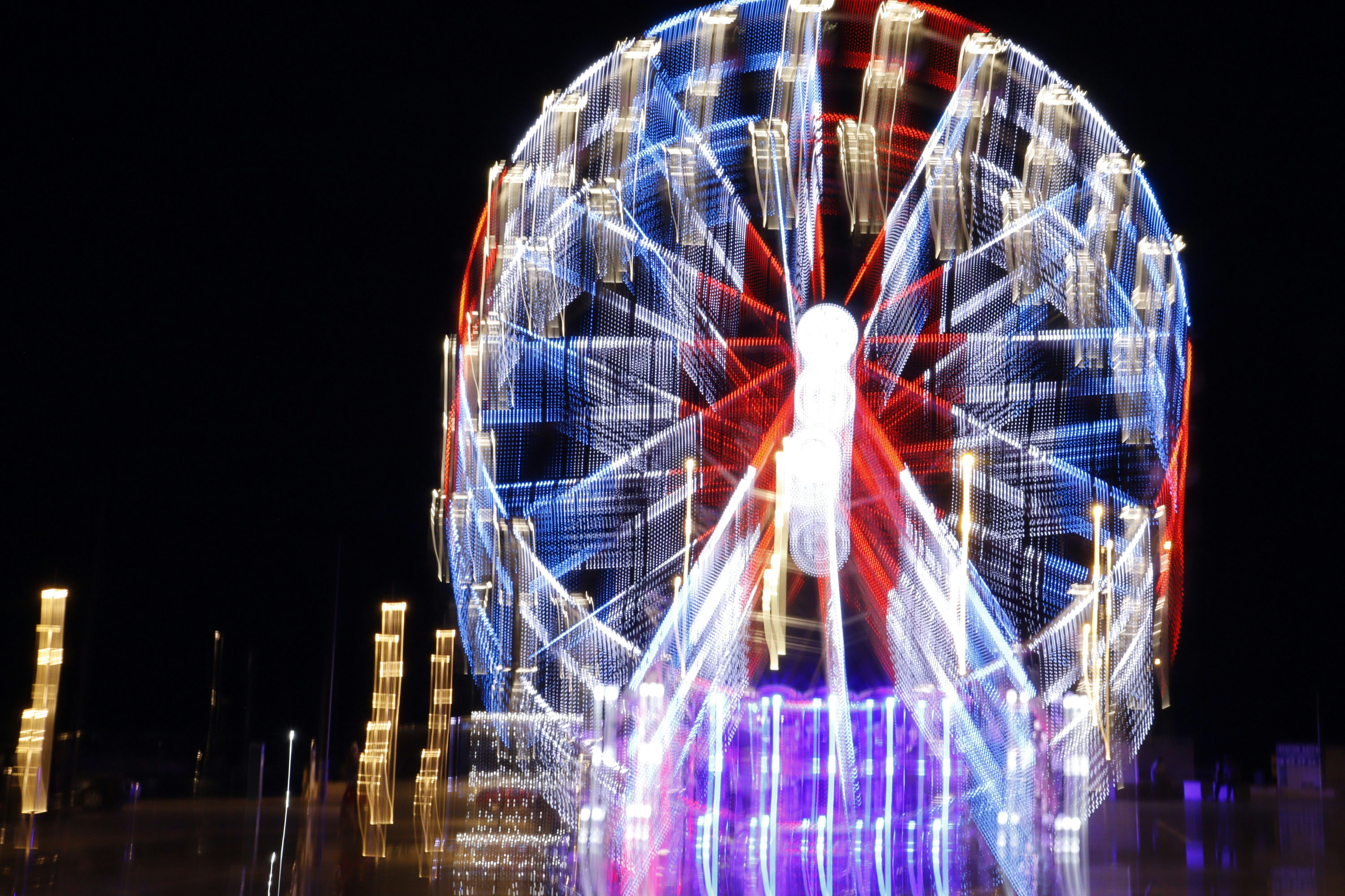 a ferris wheel lit up at night with lights