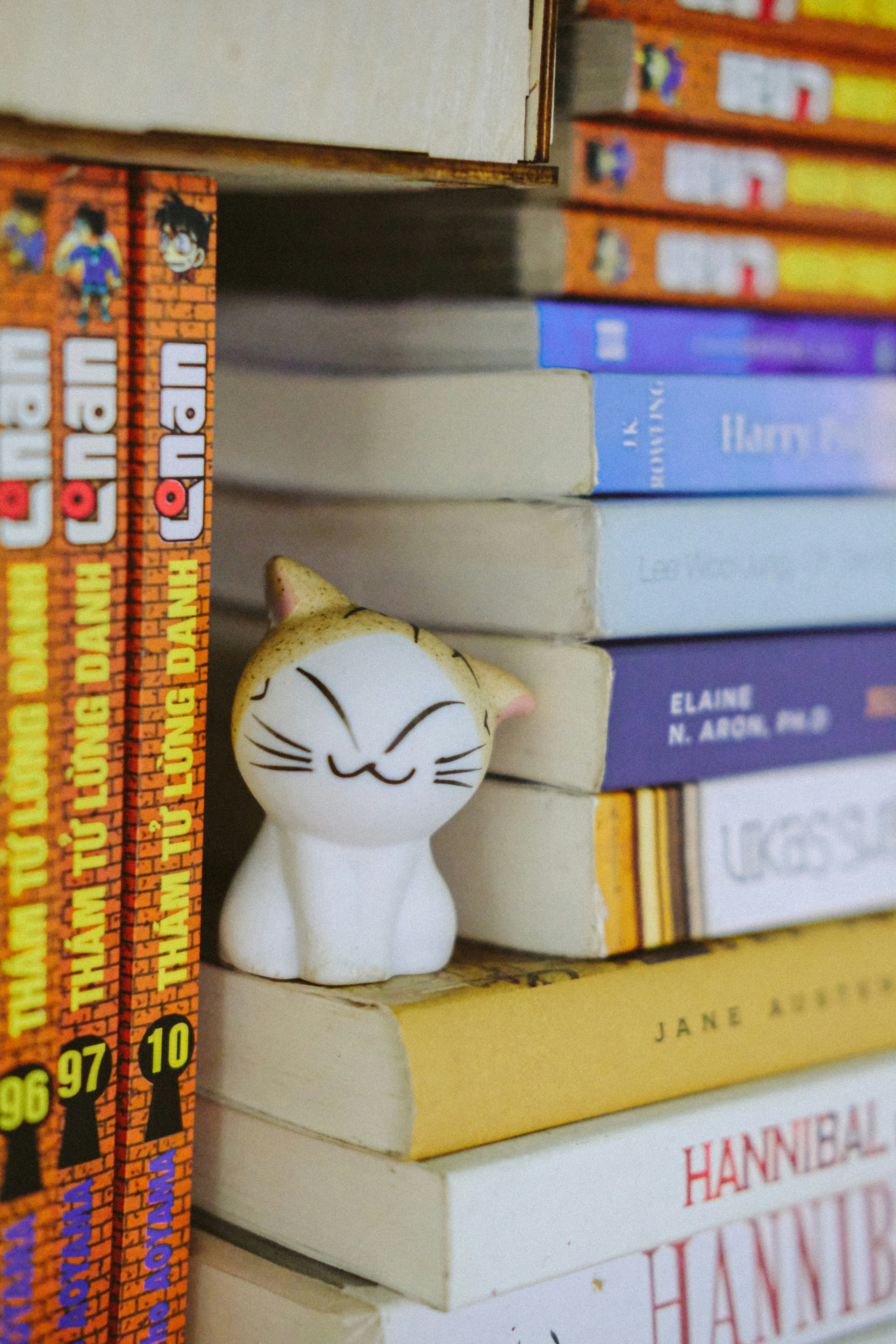 a cat figurine sitting on top of a stack of books