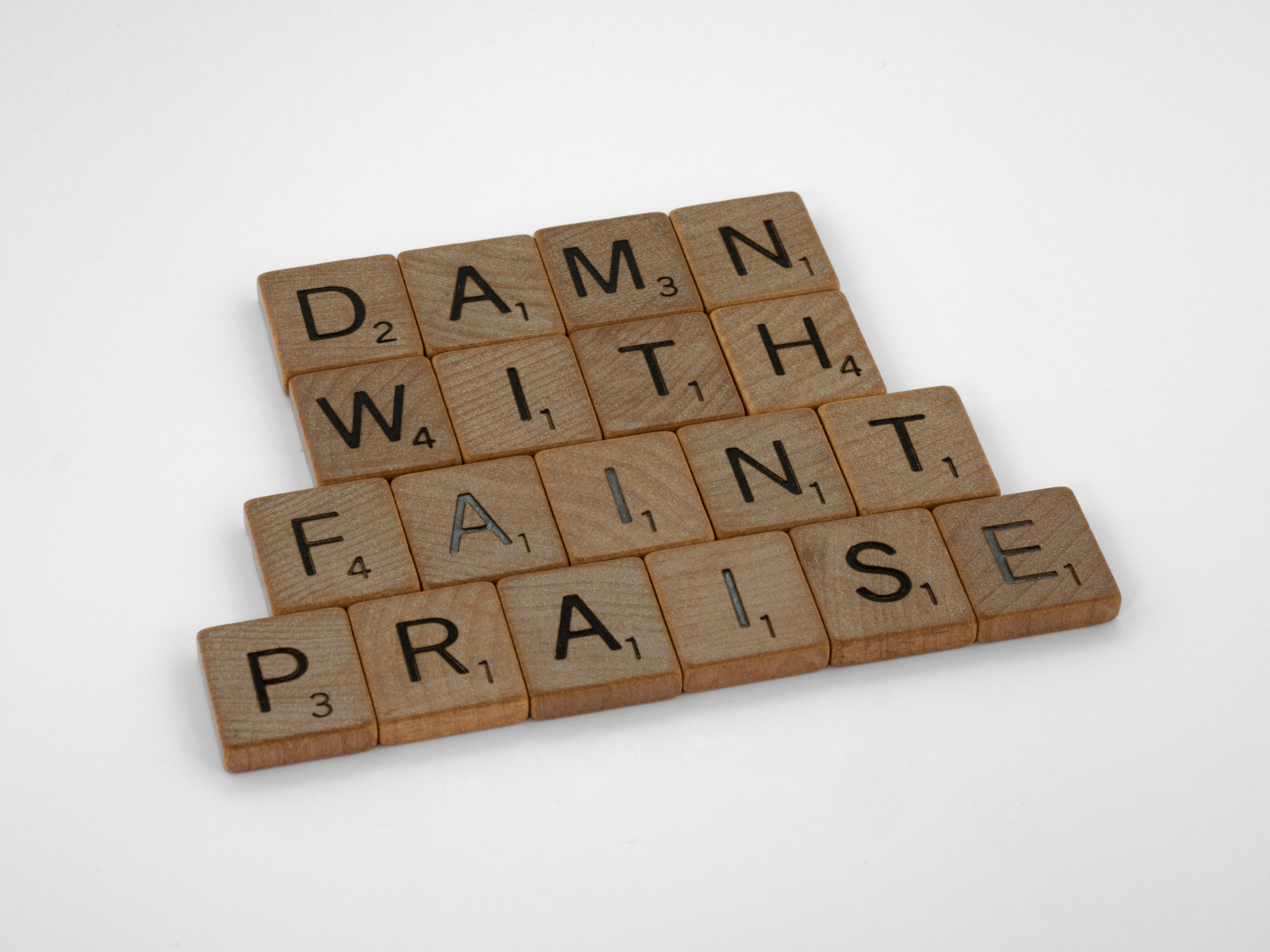 Scrabble tiles spelling damn with faint praise photo – Free Grey Image ...