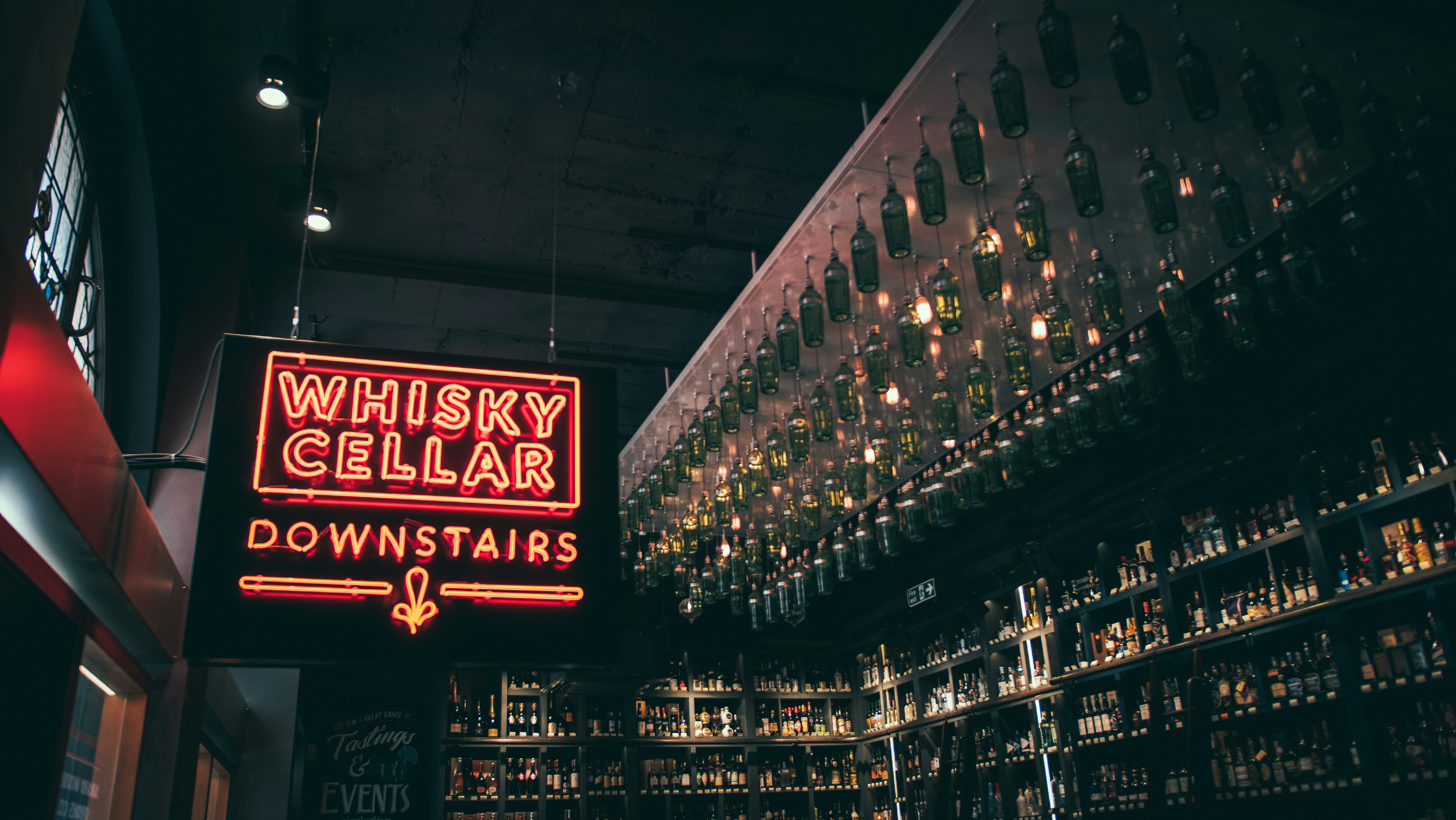 Neon Whisky Cellar Glow Across Stacked Bottles