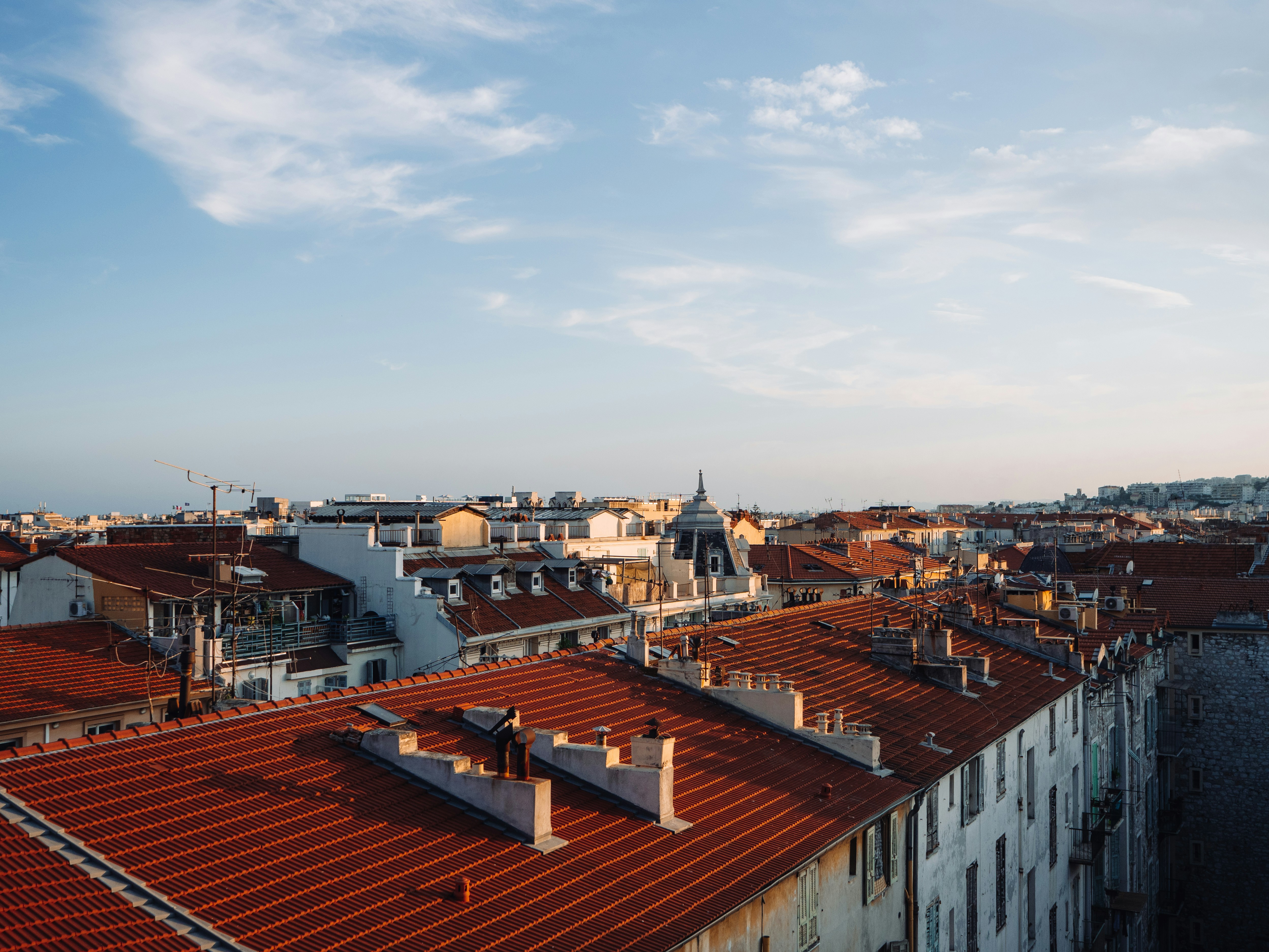 Terracotta rooftops of a cityscape under a serene evening sky, showcasing urban architecture and vibrant colors.